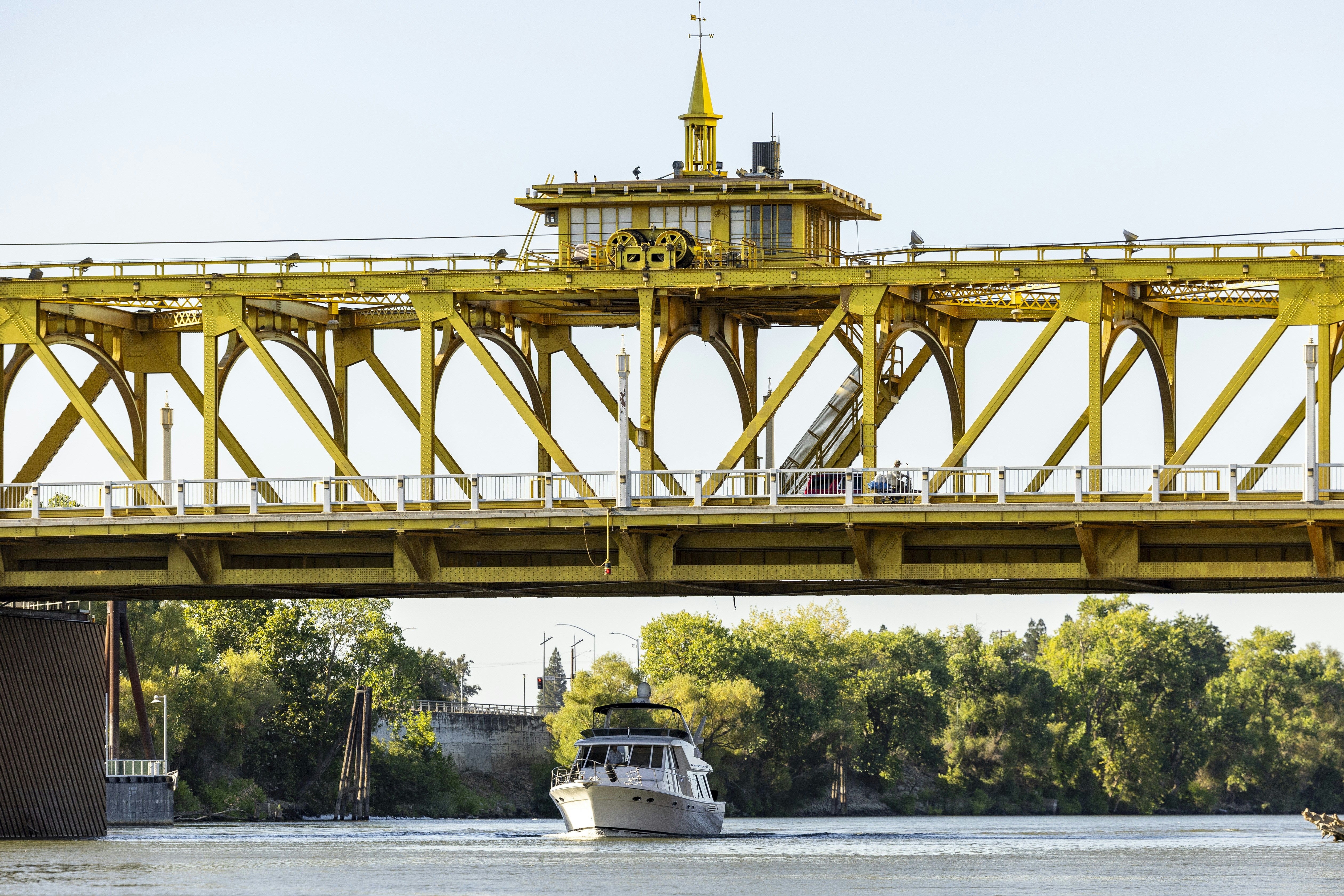 Golden Arches Over the River: A White Boat Beneath a Steel Landmark