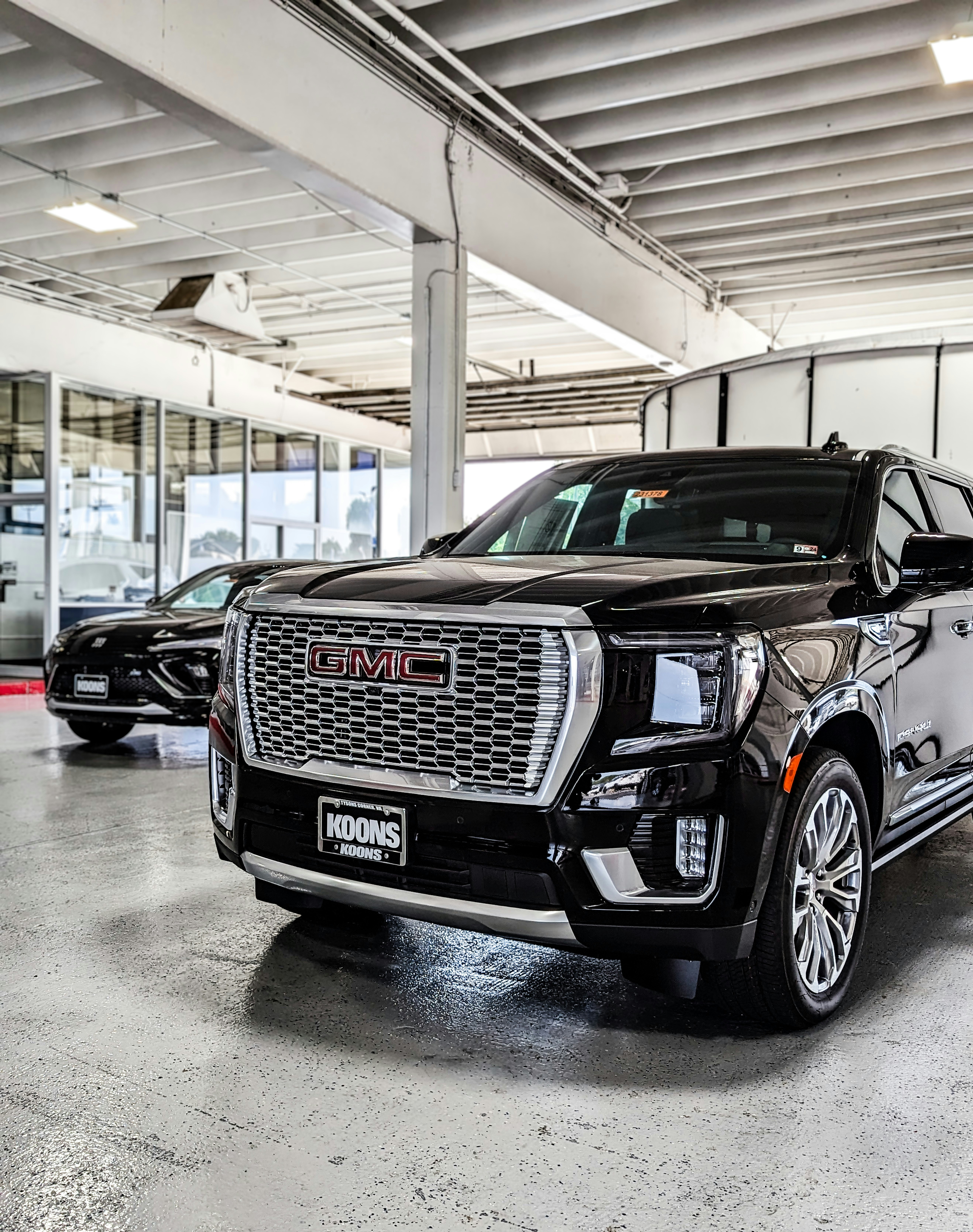 GMC Presence: A Bold Black SUV Anchors a Modern Showroom