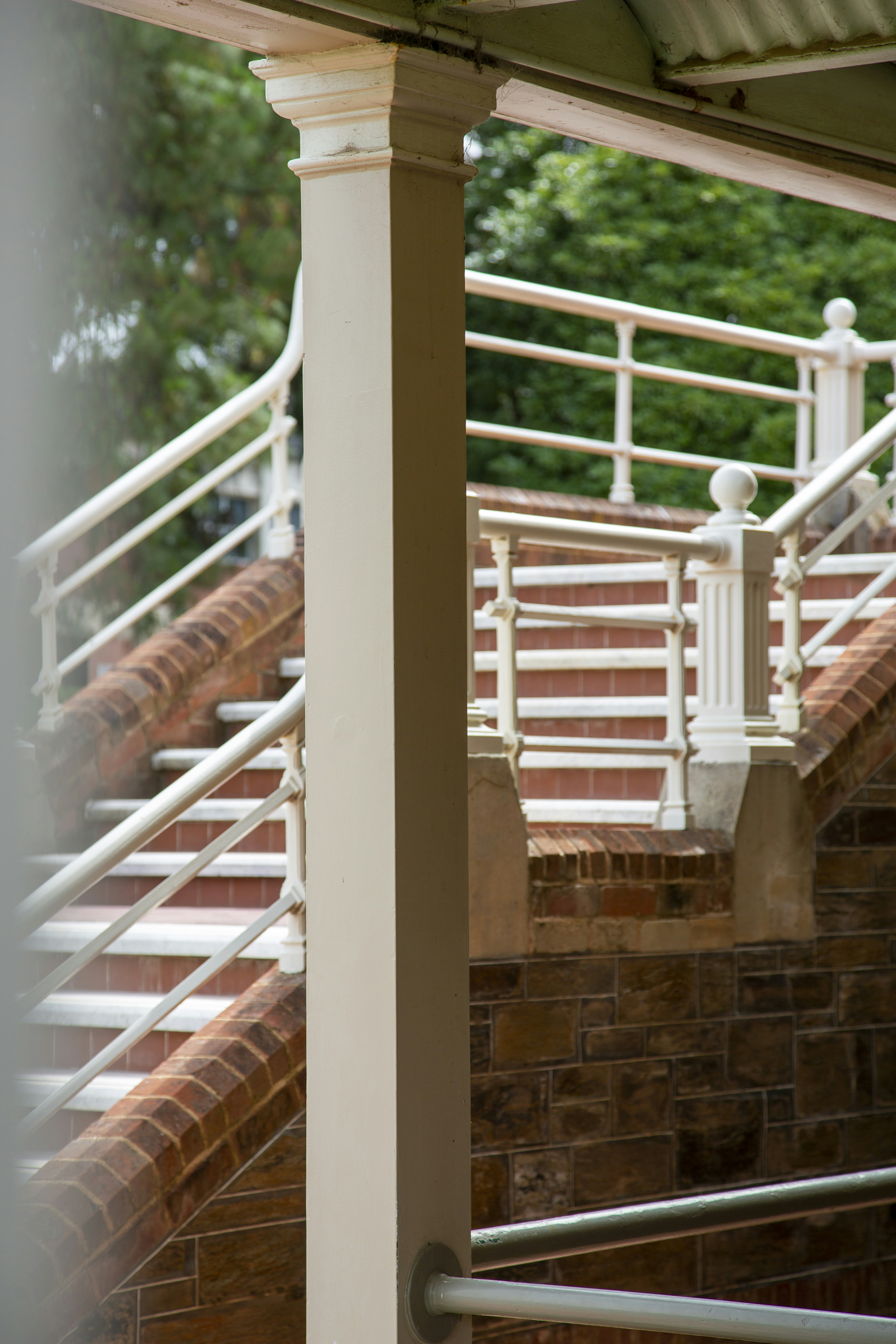Curved Rail and Brick Staircase Framing a Quiet Terrace
