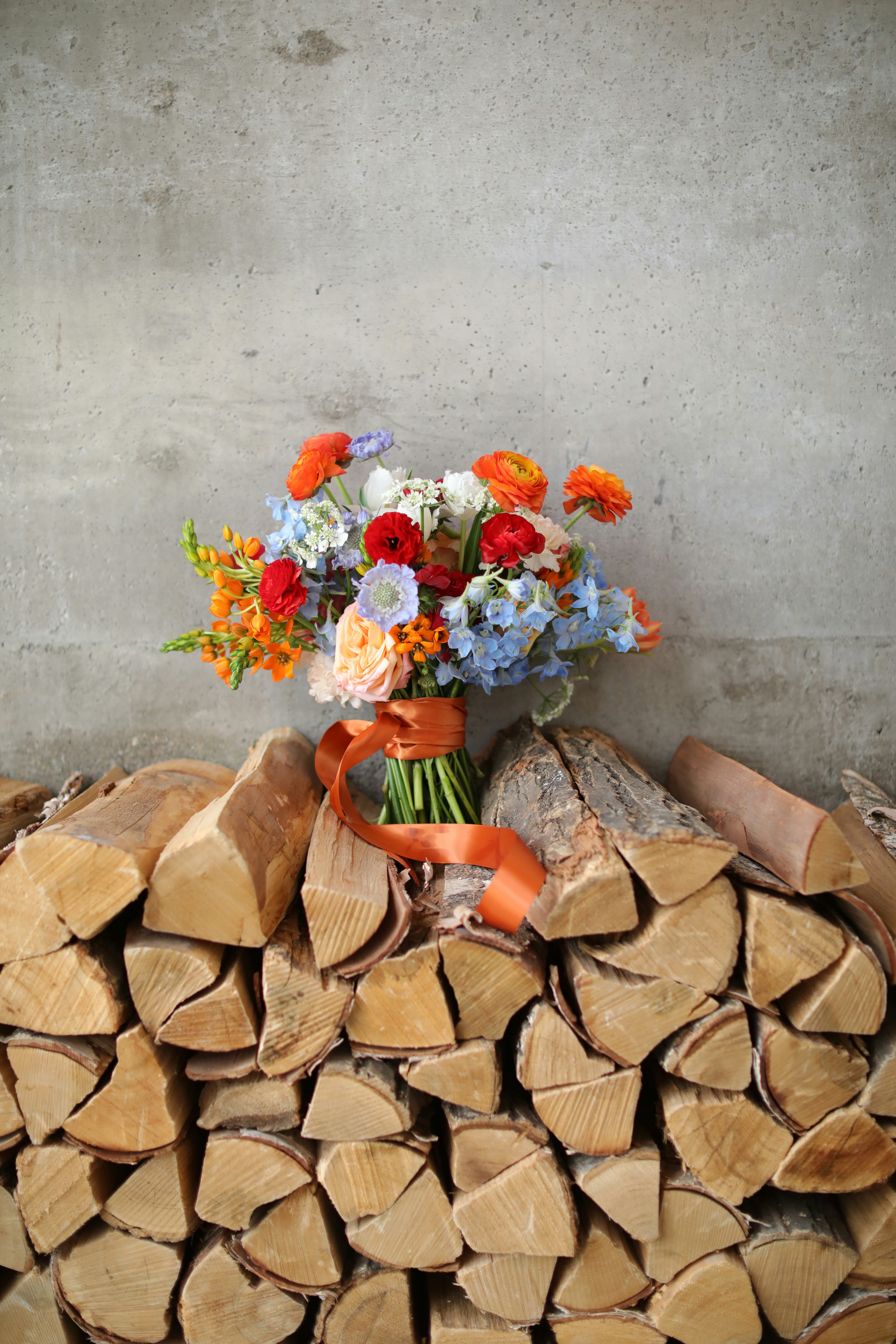 Bouquet of Fire and Ice Tied with Satin Ribbon on a Log Stack