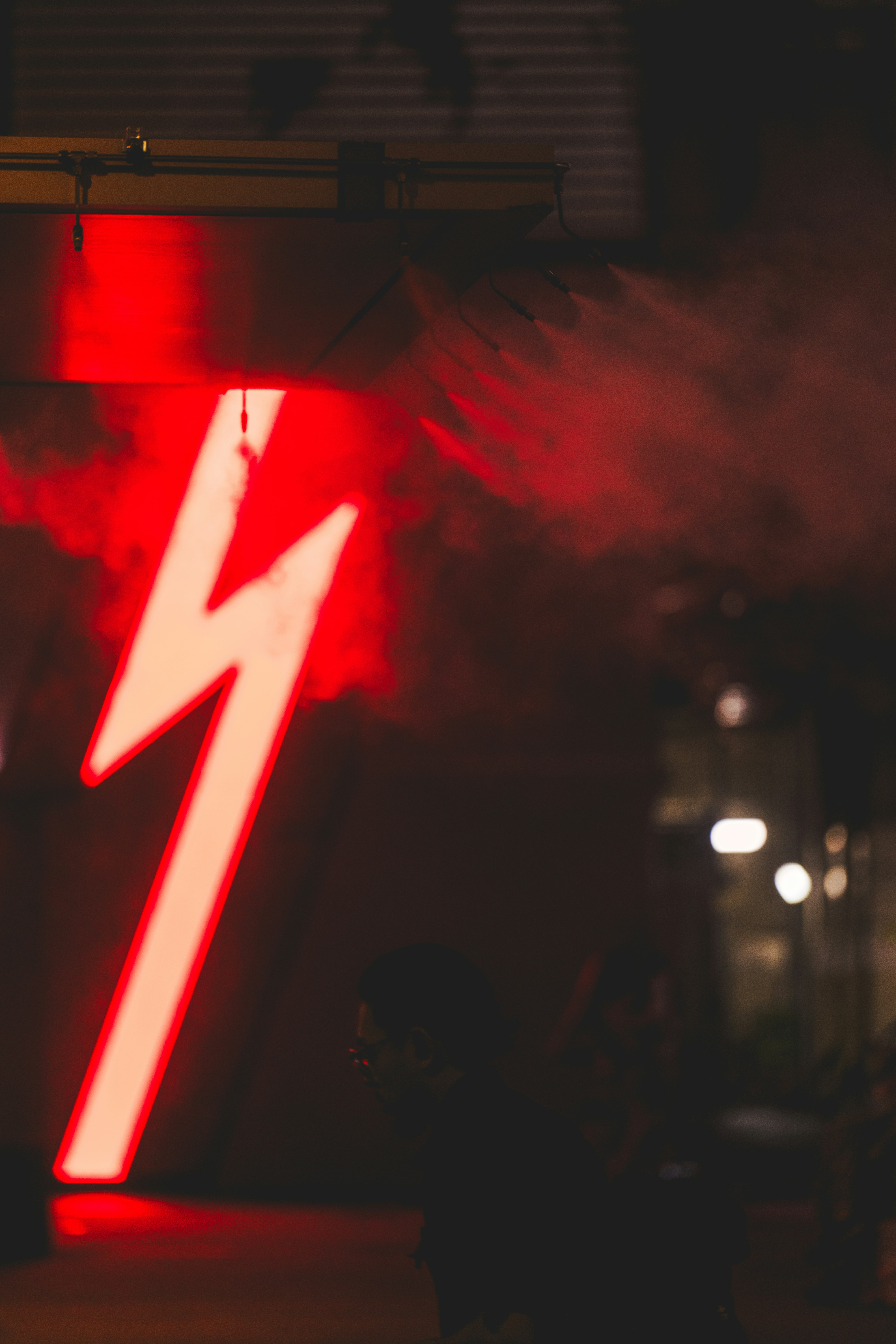 Crimson Neon Bolt Luminous in Smoke: A Nightstage Portrait