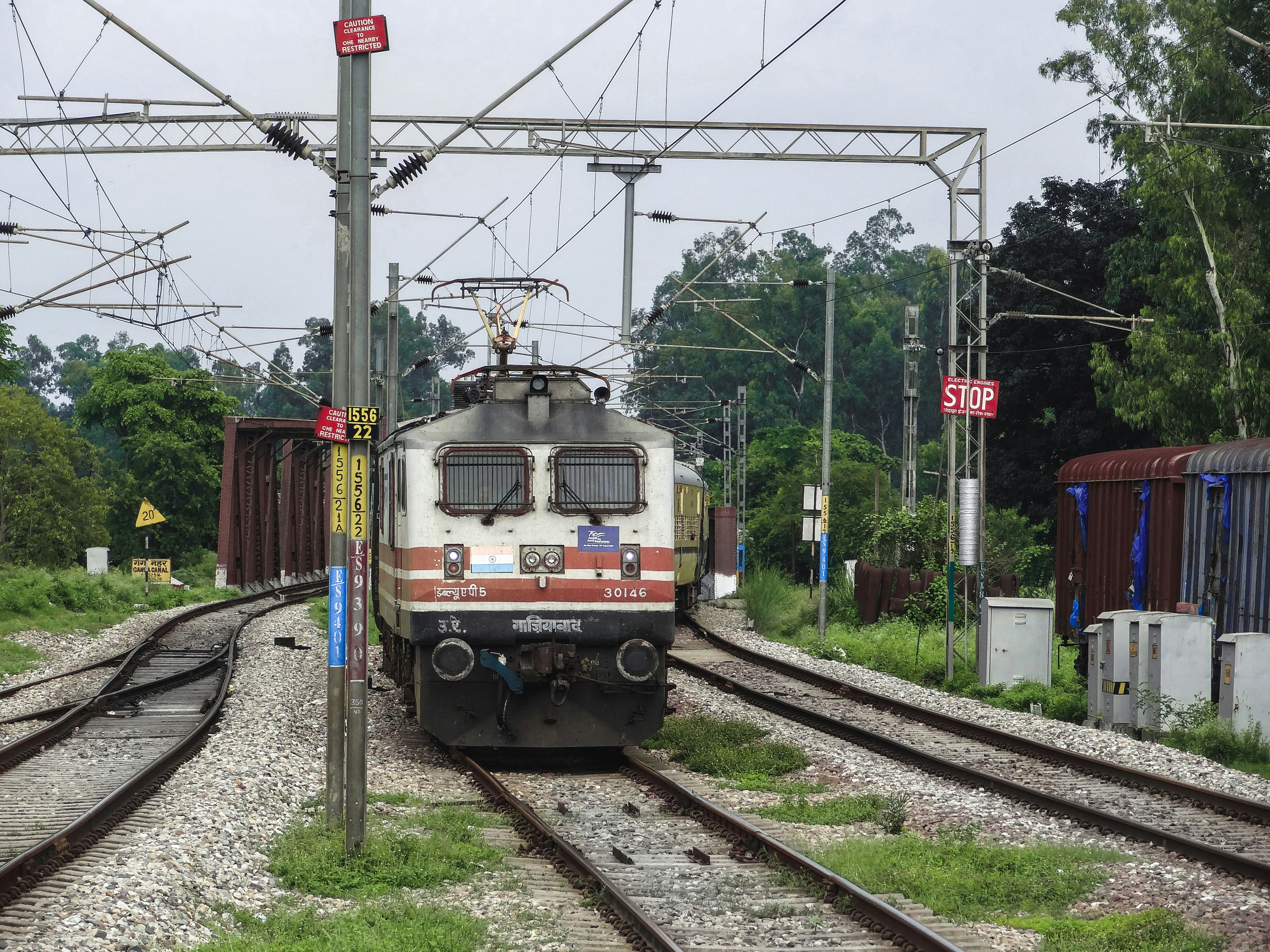 A train traveling down train tracks next to a forest photo – Free Roorkee Image on Unsplash