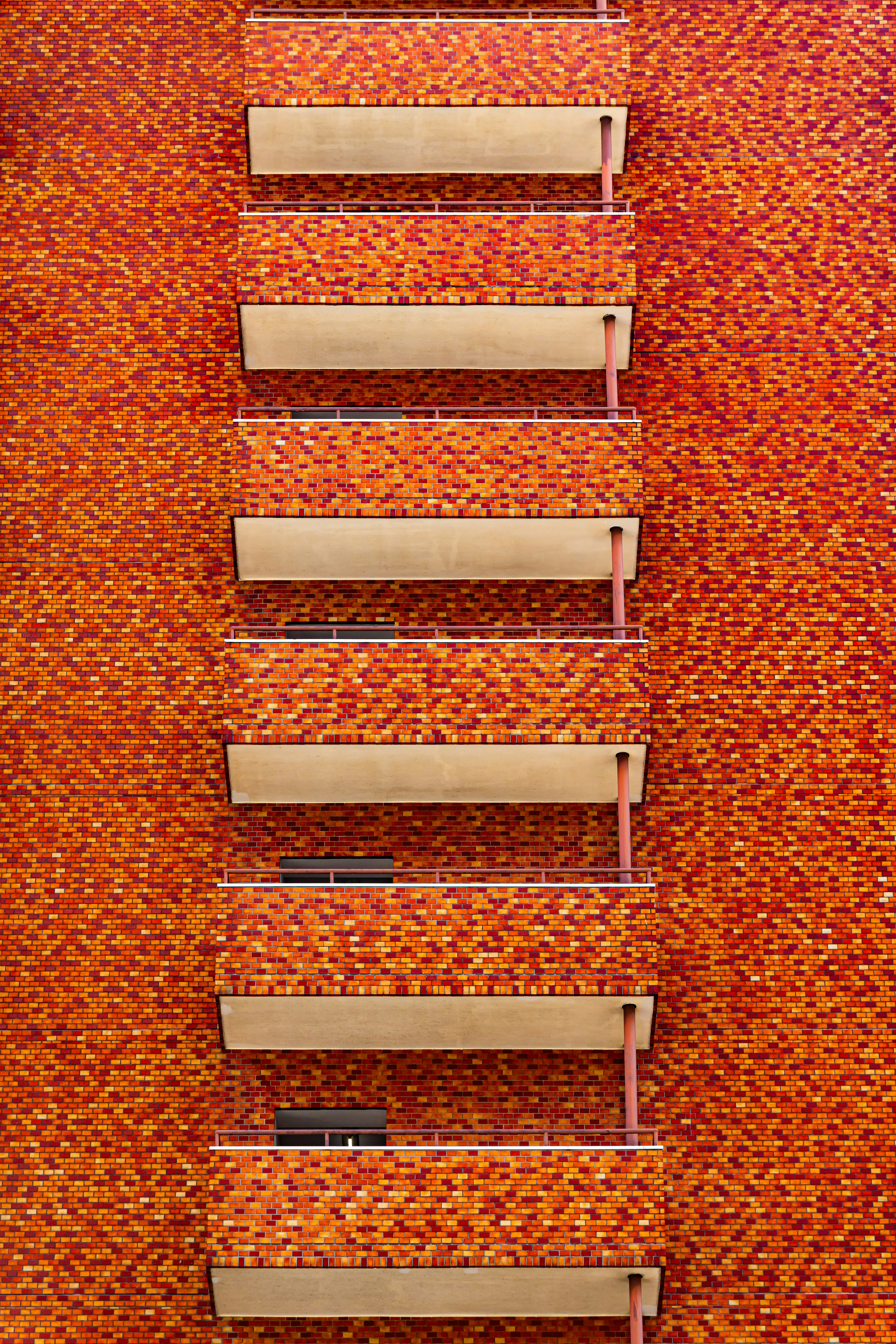 Vertical Rhythm of Beige Balconies on a Brick Facade