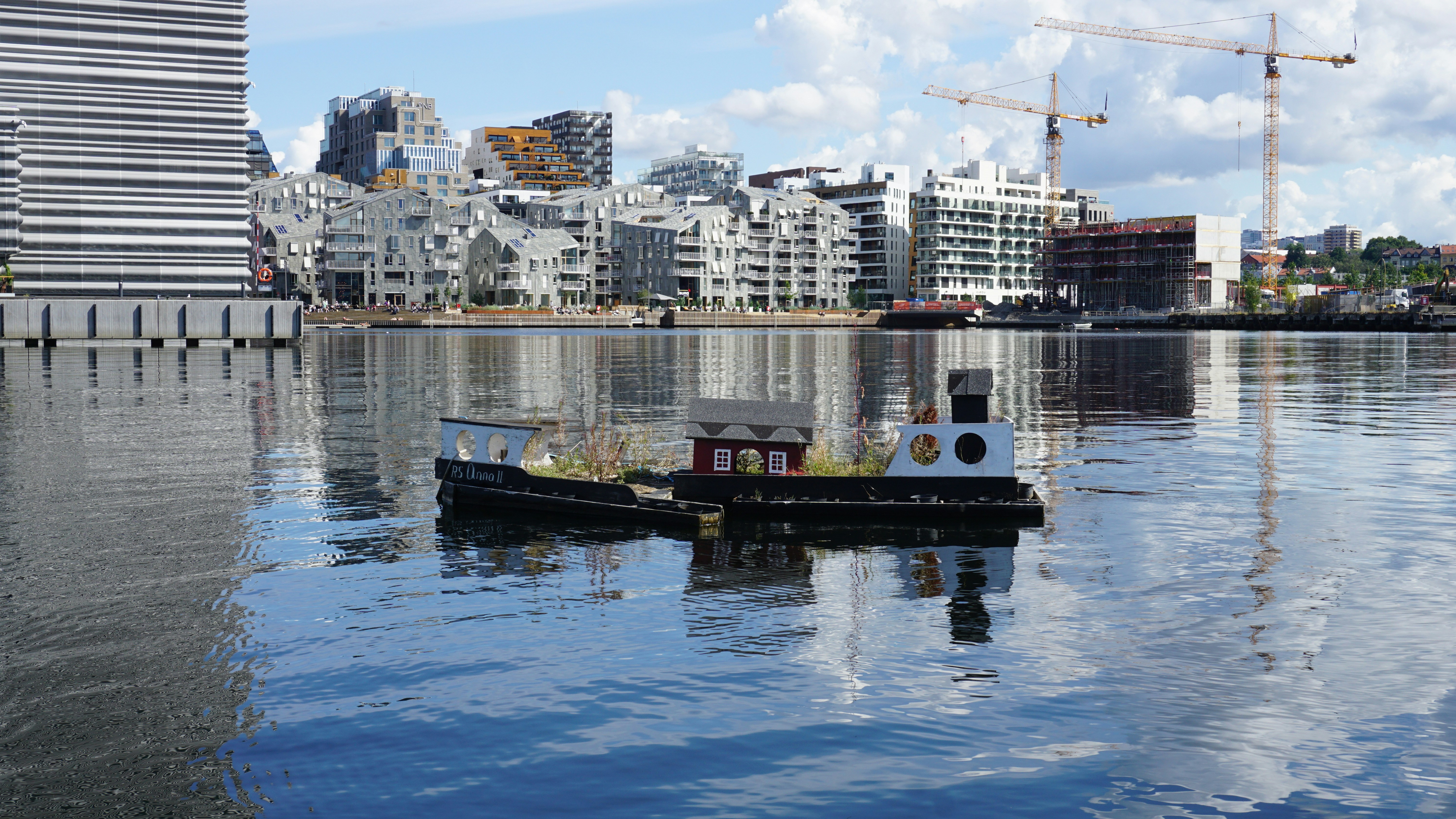 Glassy Harbor, Tiny Barge, Big City: A Quiet Moment by the Crane