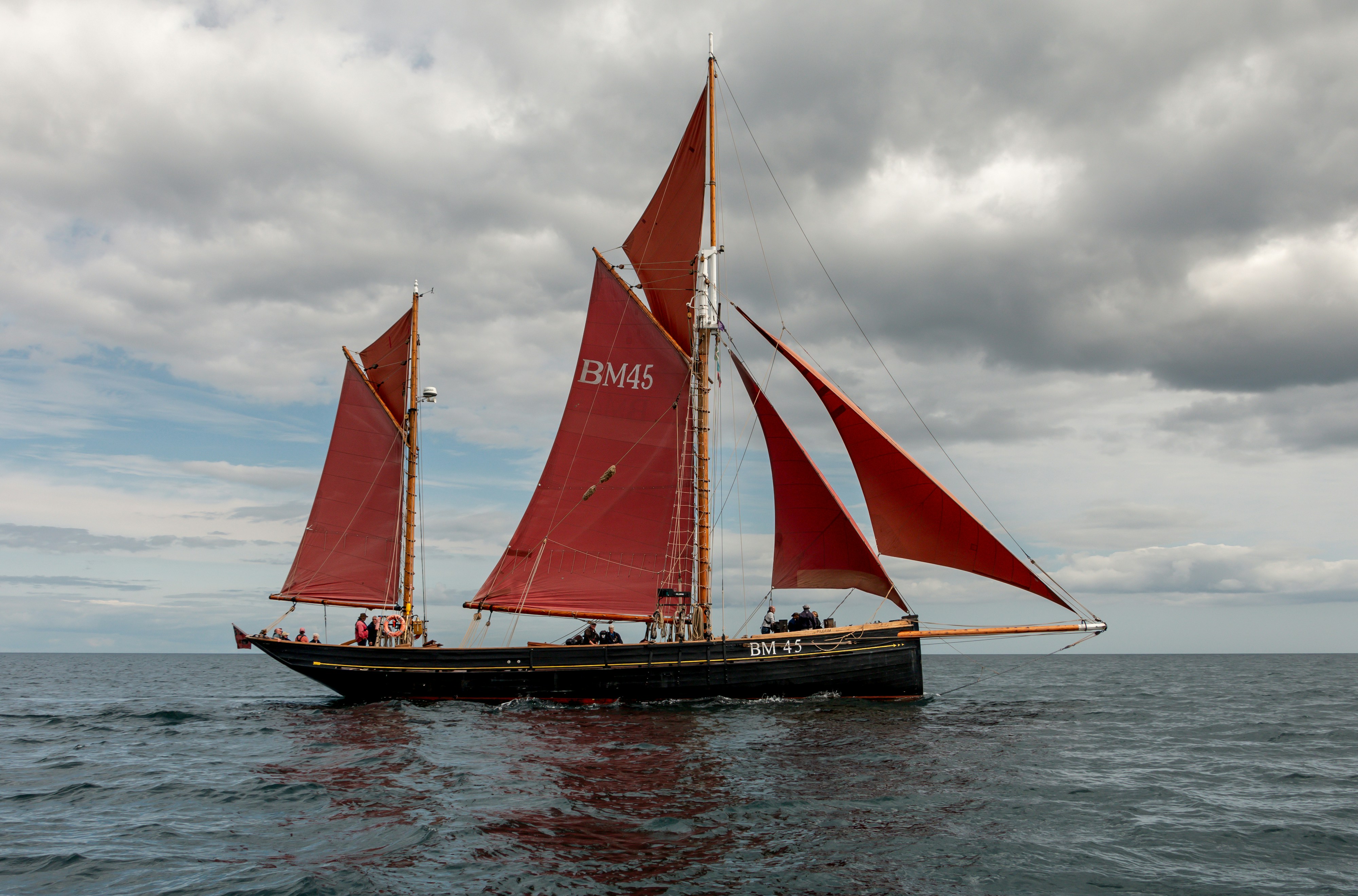 A sailboat with red sails on the water photo – Free Babbacombe bay ...