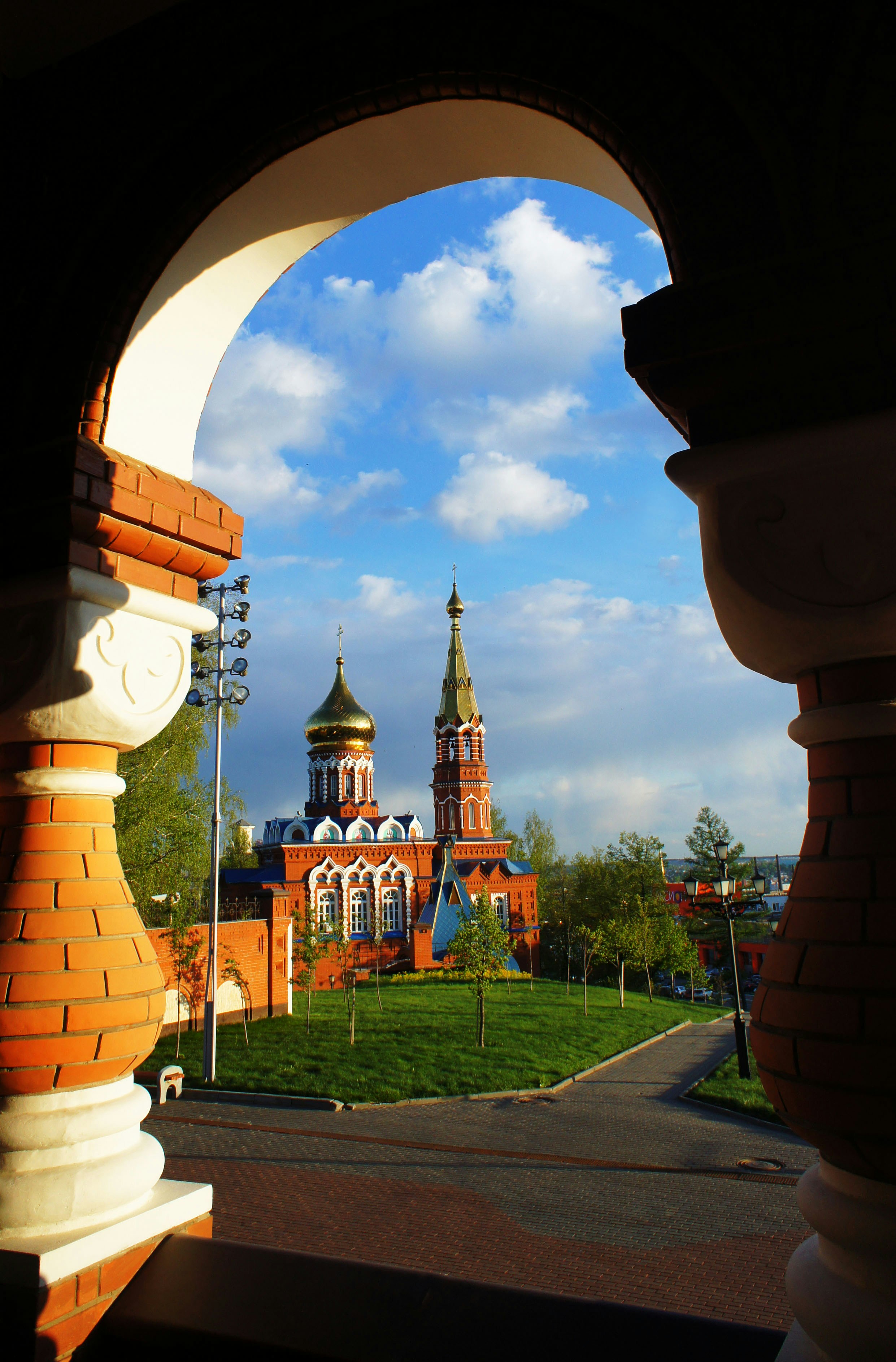 Archway Vista: Red-Brick Russian Orthodox Church Framed by Sky and Spires
