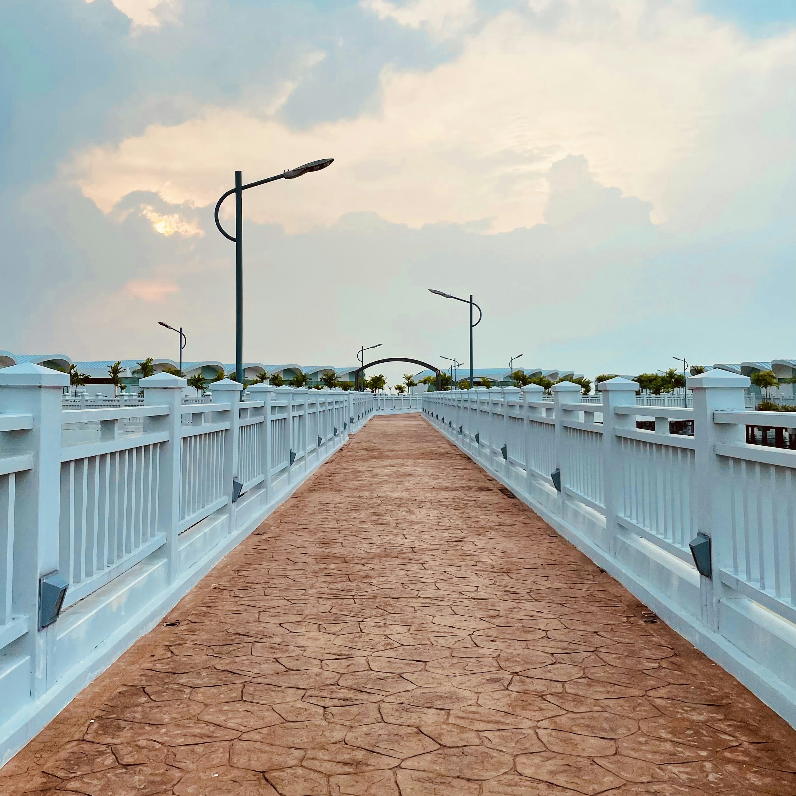 A long white bridge with a light pole and street lights photo – Free ...