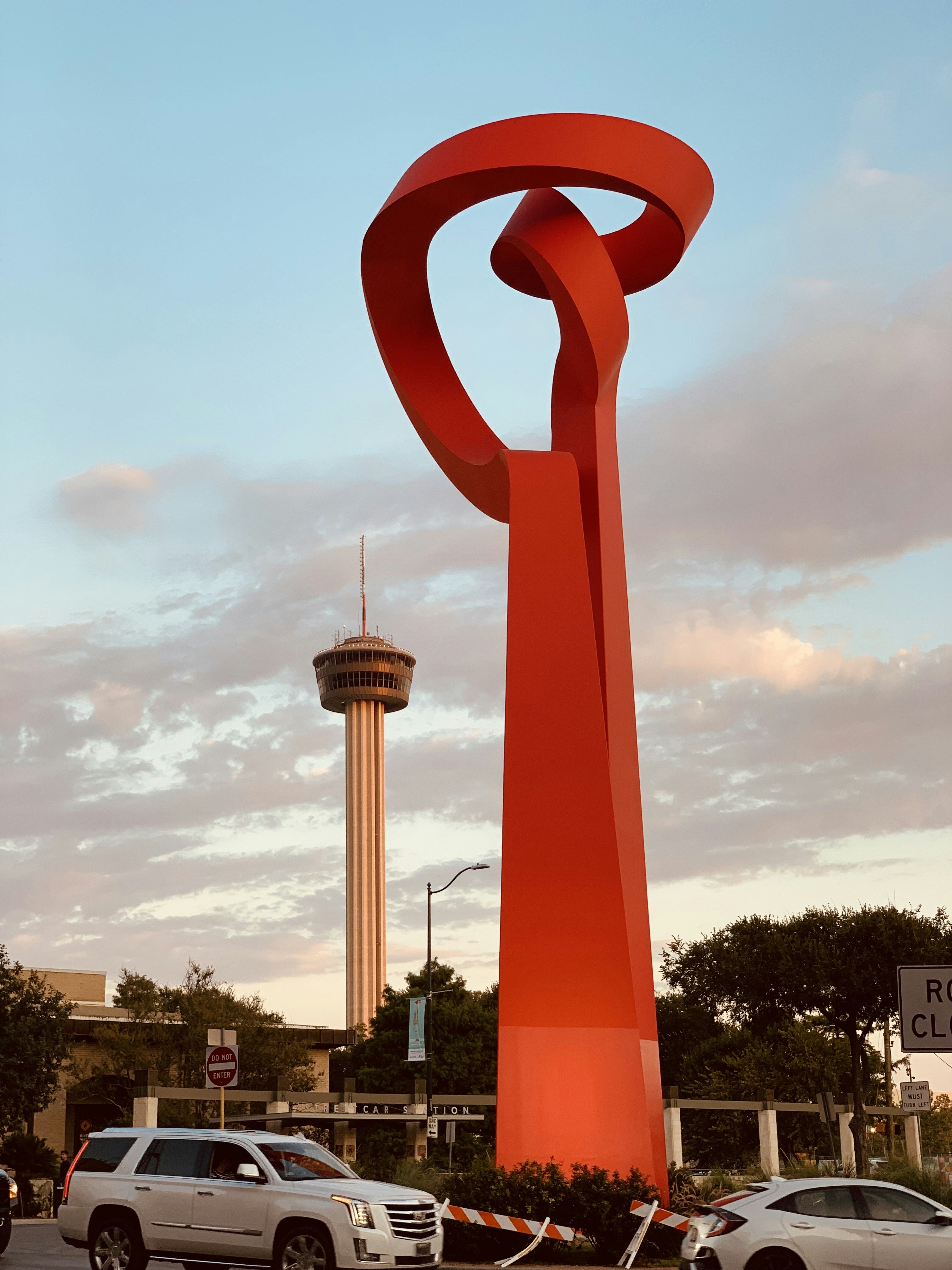 A large red sculpture in the middle of a parking lot photo – Free ...