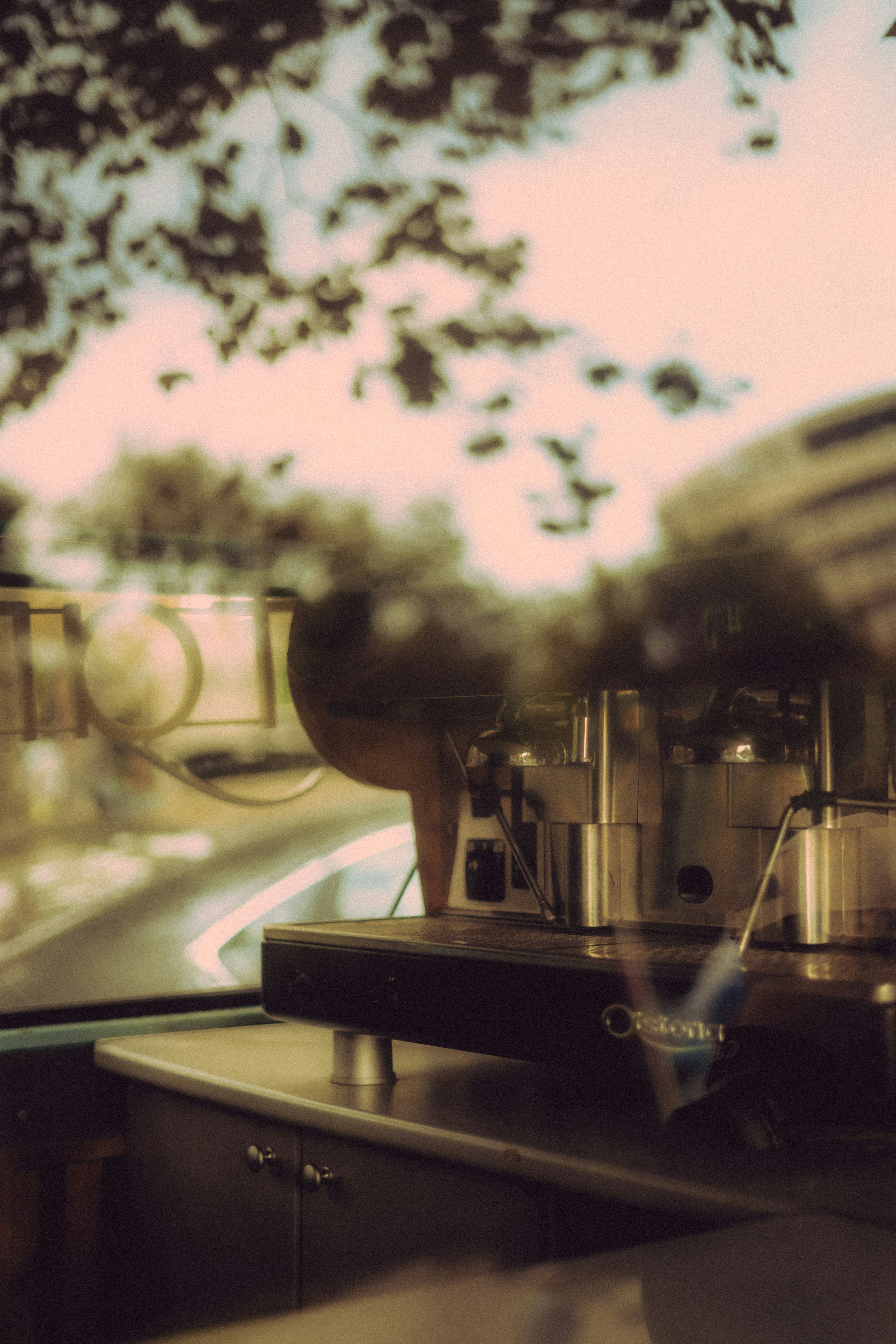 Dappled Reflections: A Cafe Espresso Machine in Soft Focus