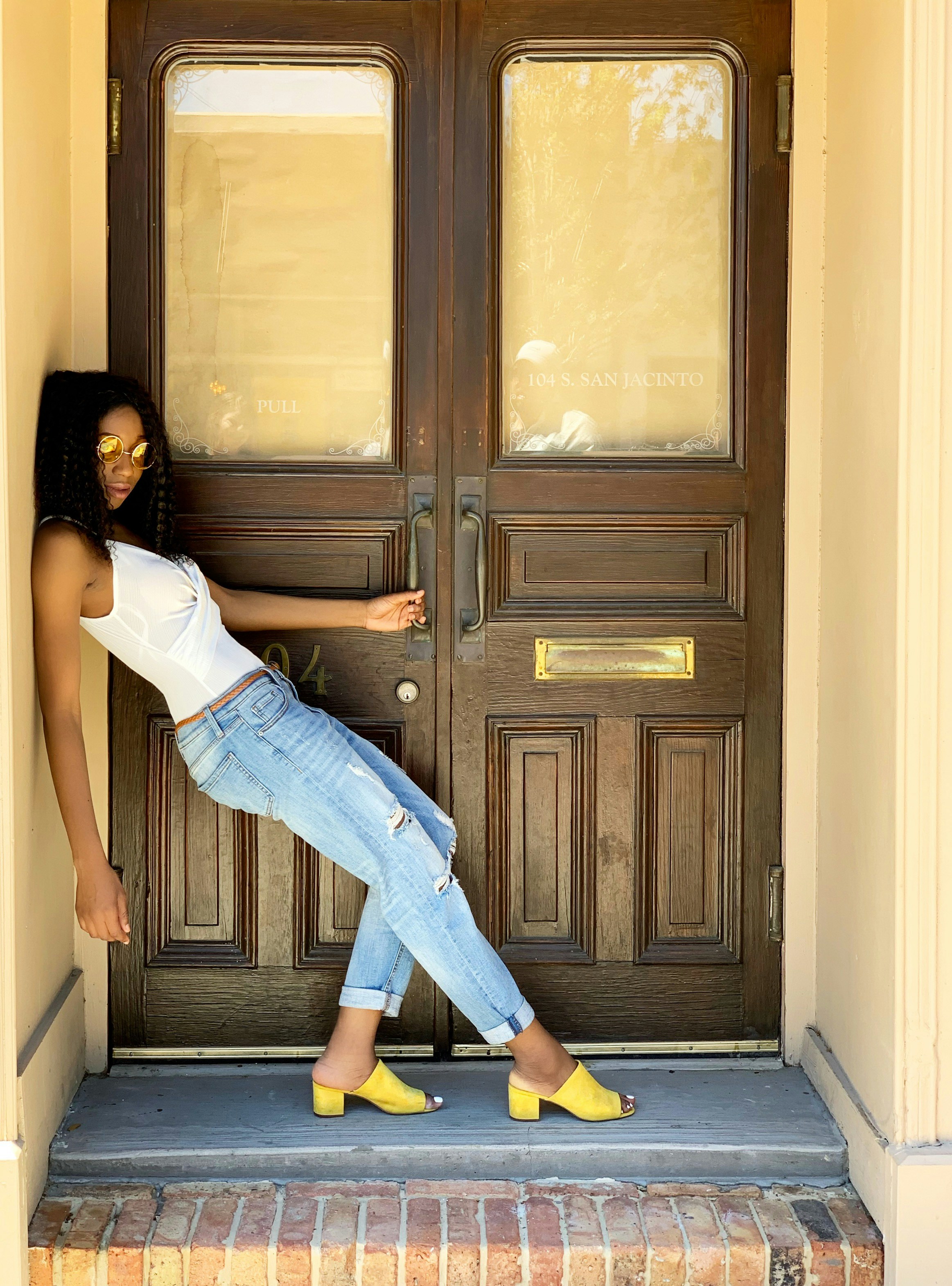 A woman leaning against the door of a house photo – Free Jeans Image on ...