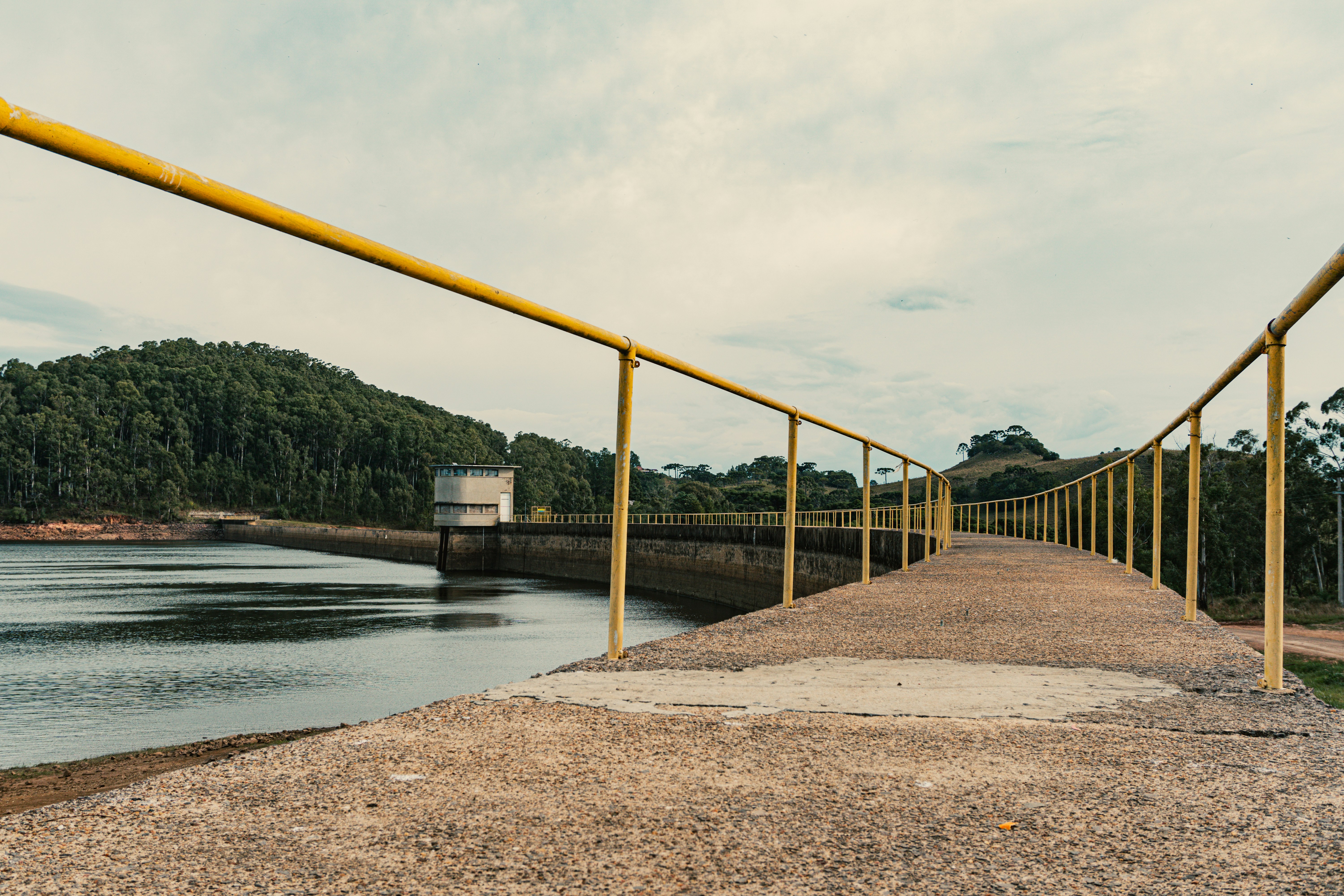 A long yellow railing next to a body of water photo – Free Nature Image ...