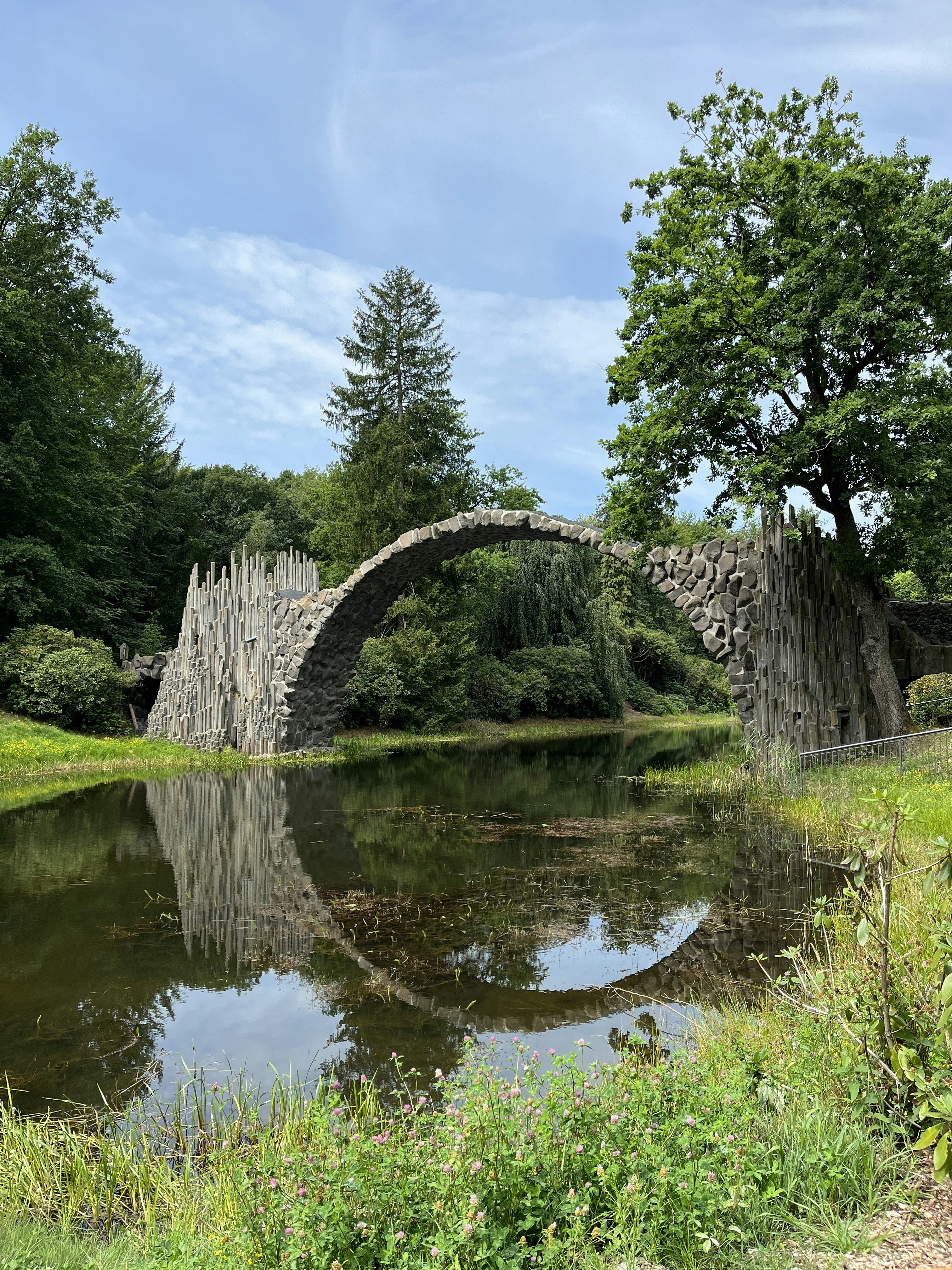 A stone bridge over a pond in a park photo – Free Gablenz Image on Unsplash