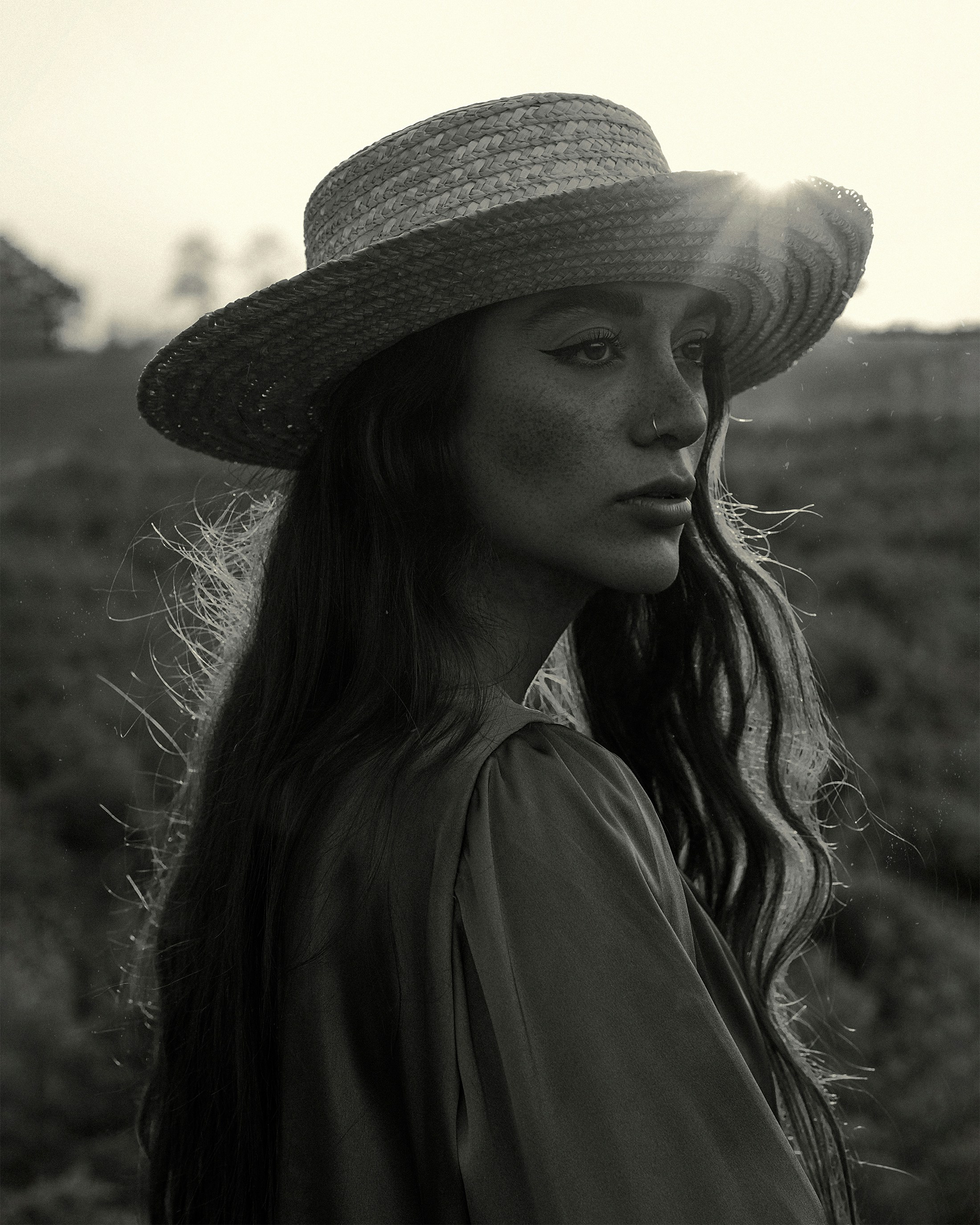 Backlit Grace: Portrait Framed by Sun and Straw Hat