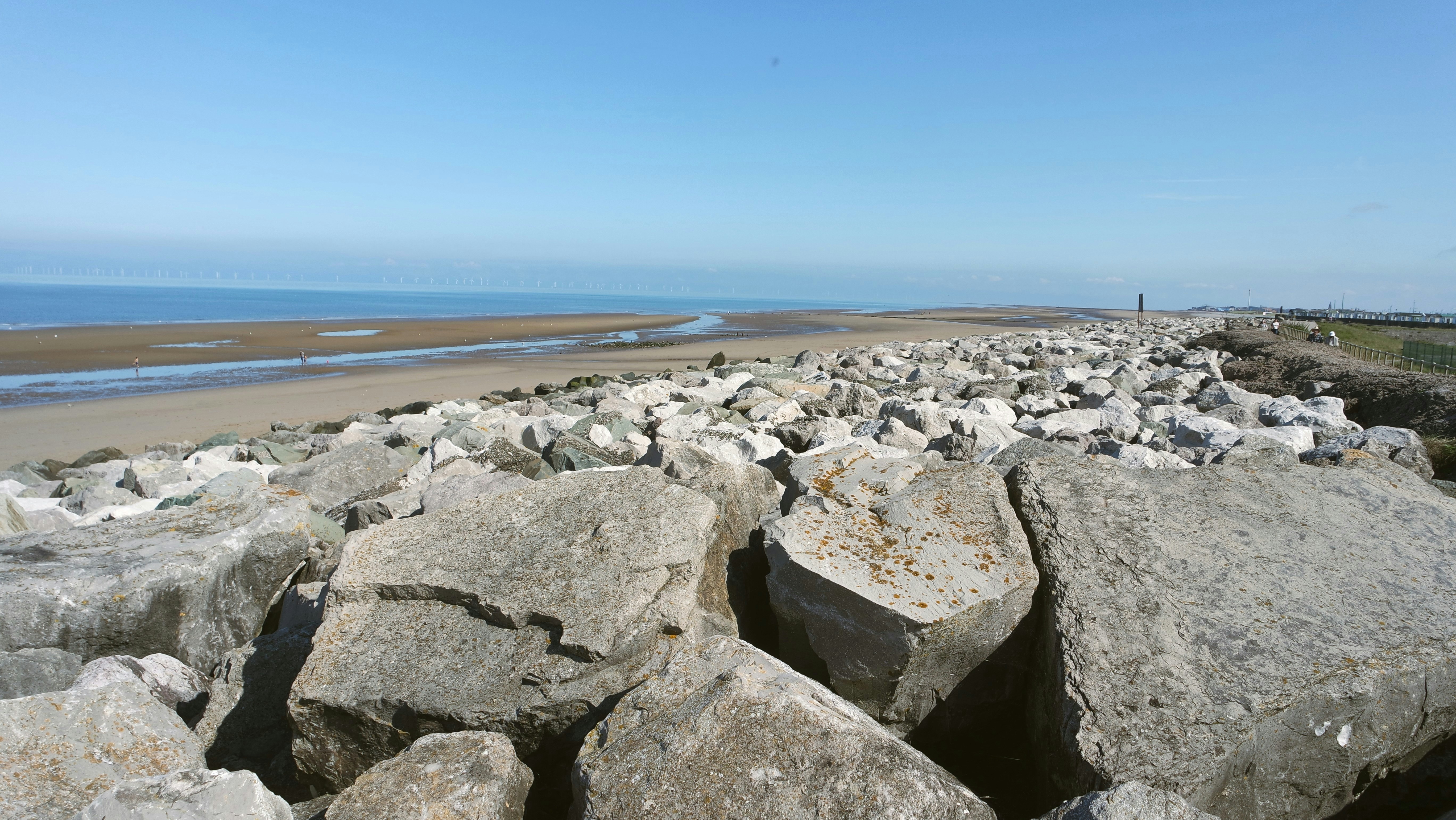 A large pile of rocks sitting on top of a beach photo – Free Beach ...
