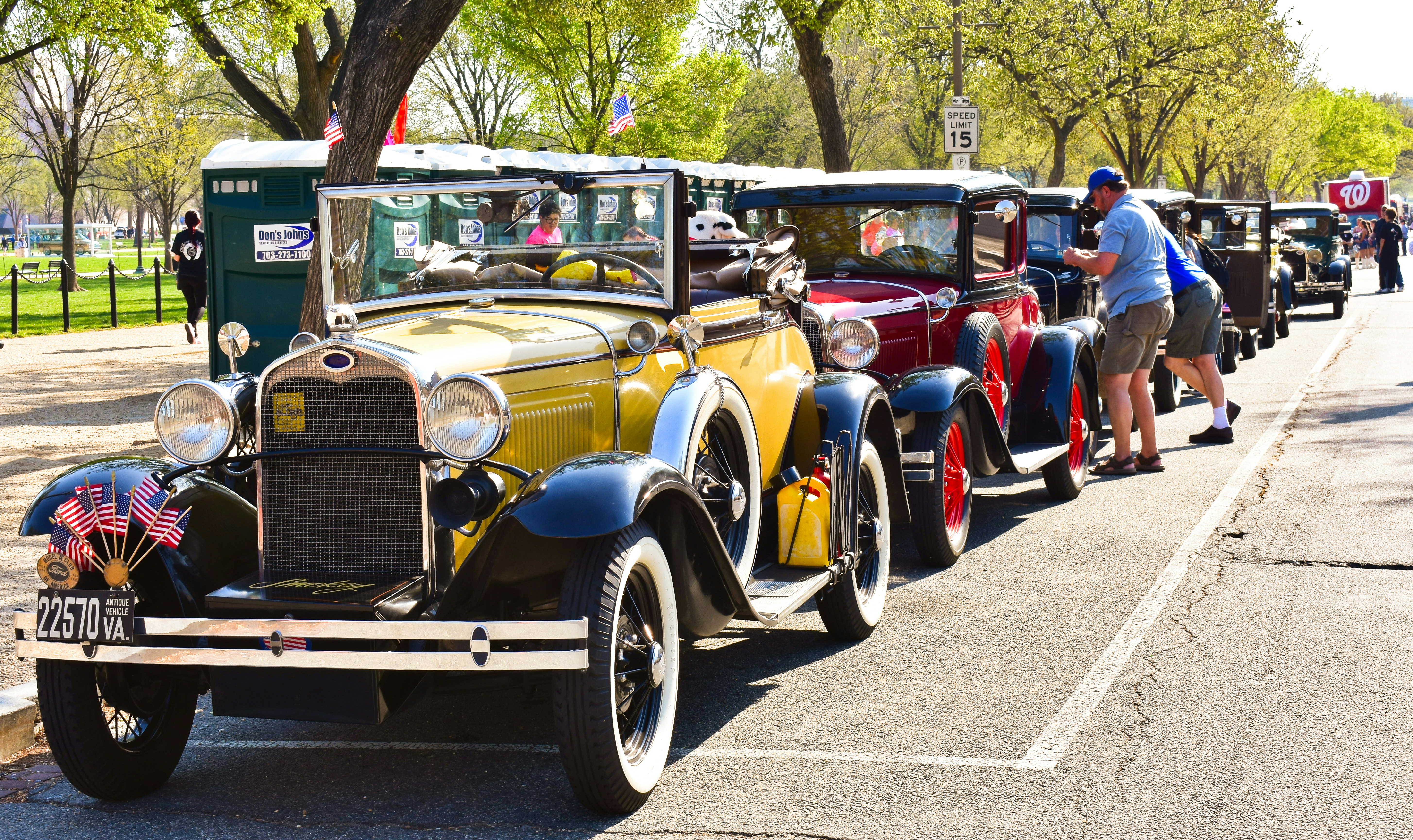 Sunlit Row of Vintage Roadsters: A Classic Car Show Parade