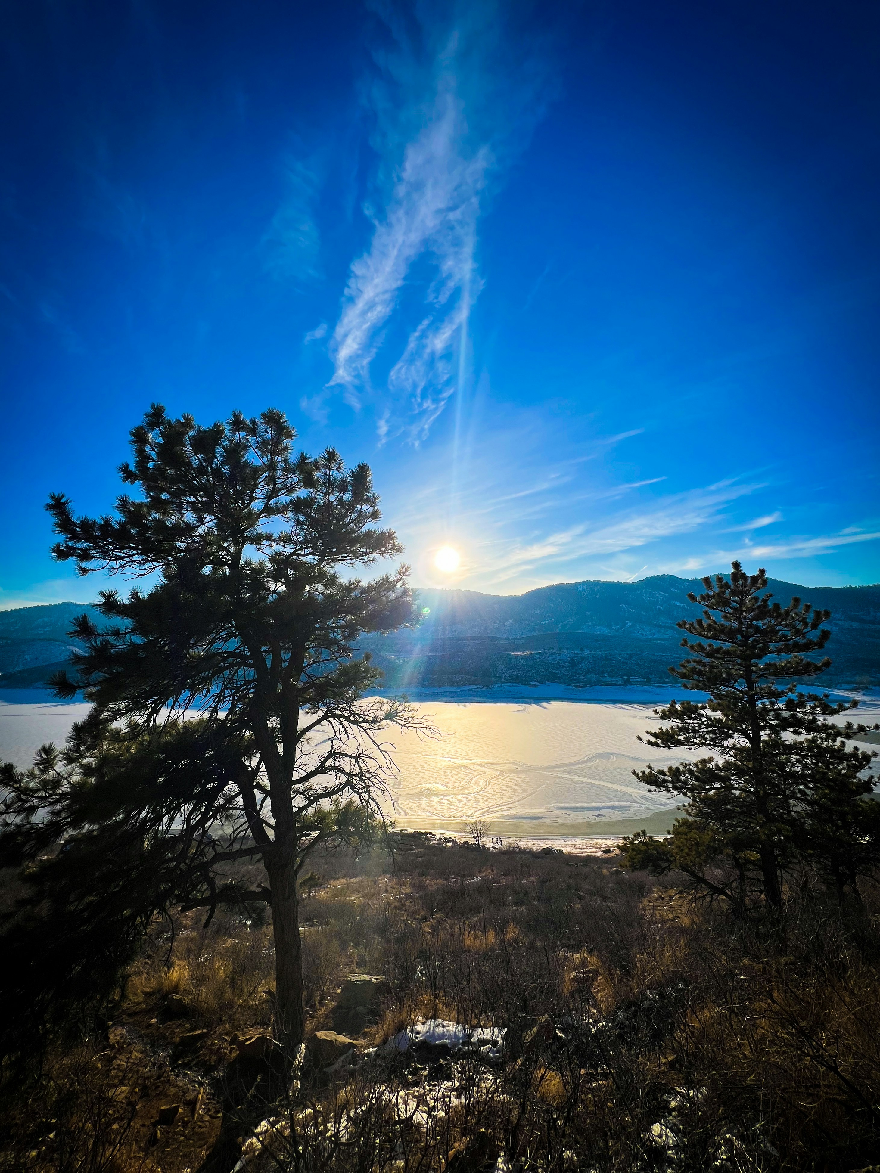 Sunburst Over a Snow-Dusted Lake, Pine-Framed Horizon