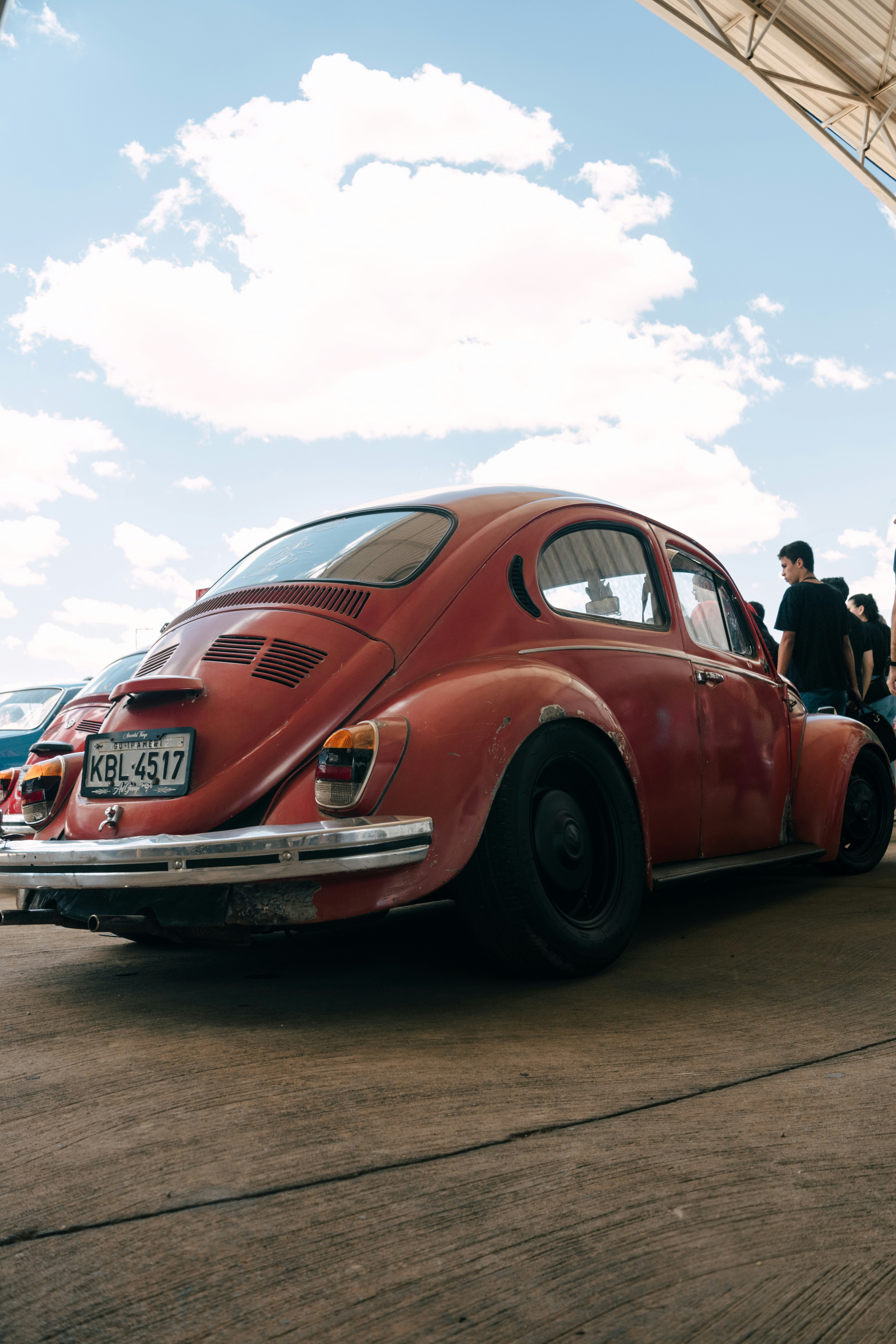 A red vw bug parked in a parking lot photo – Free Wheel Image on Unsplash