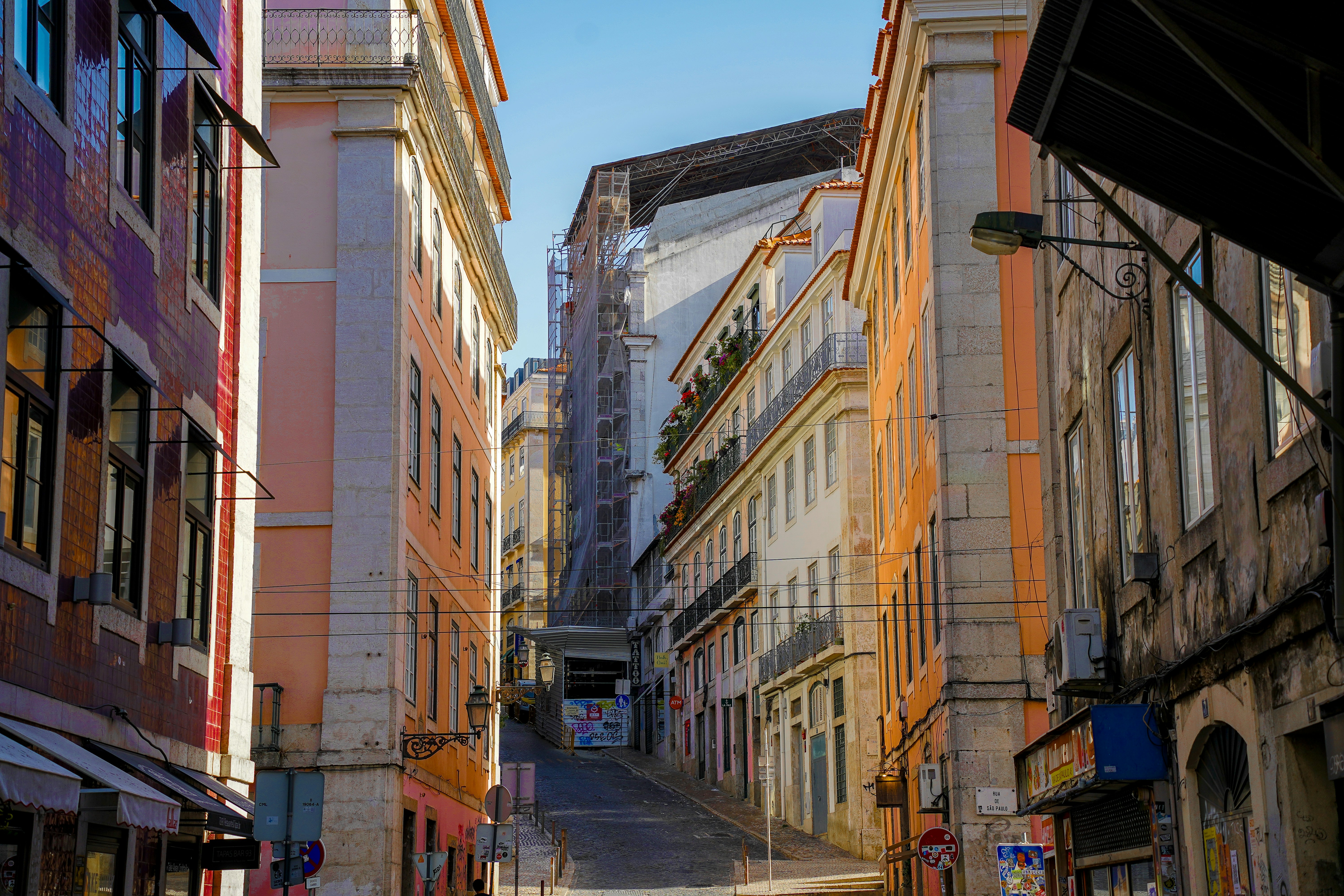 A narrow city street lined with tall buildings photo – Free City Image ...