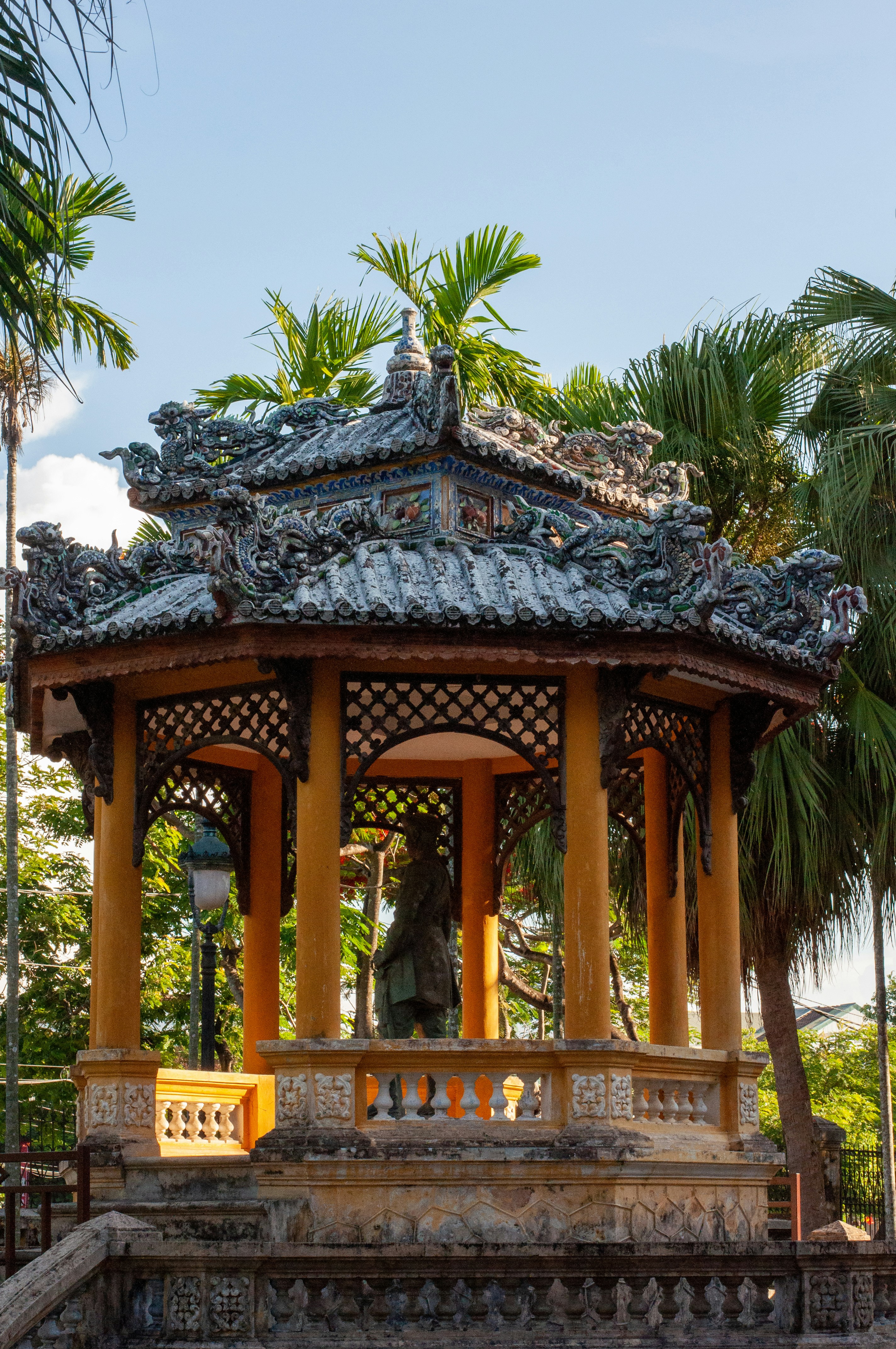 Sunlit Pavilion of Carved Dragons: A Quiet Statue Under Ornate Tiles
