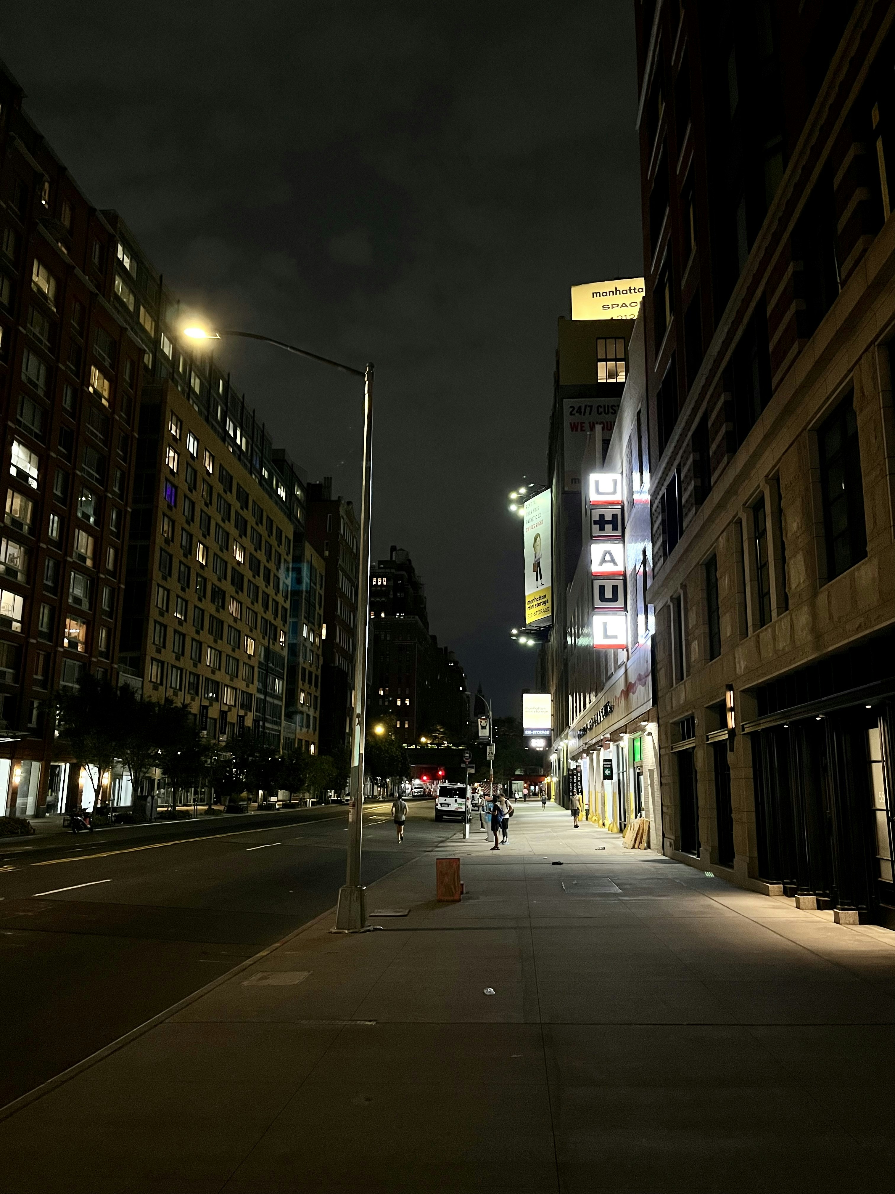 A city street at night with buildings lit up photo – Free Manhattan ...