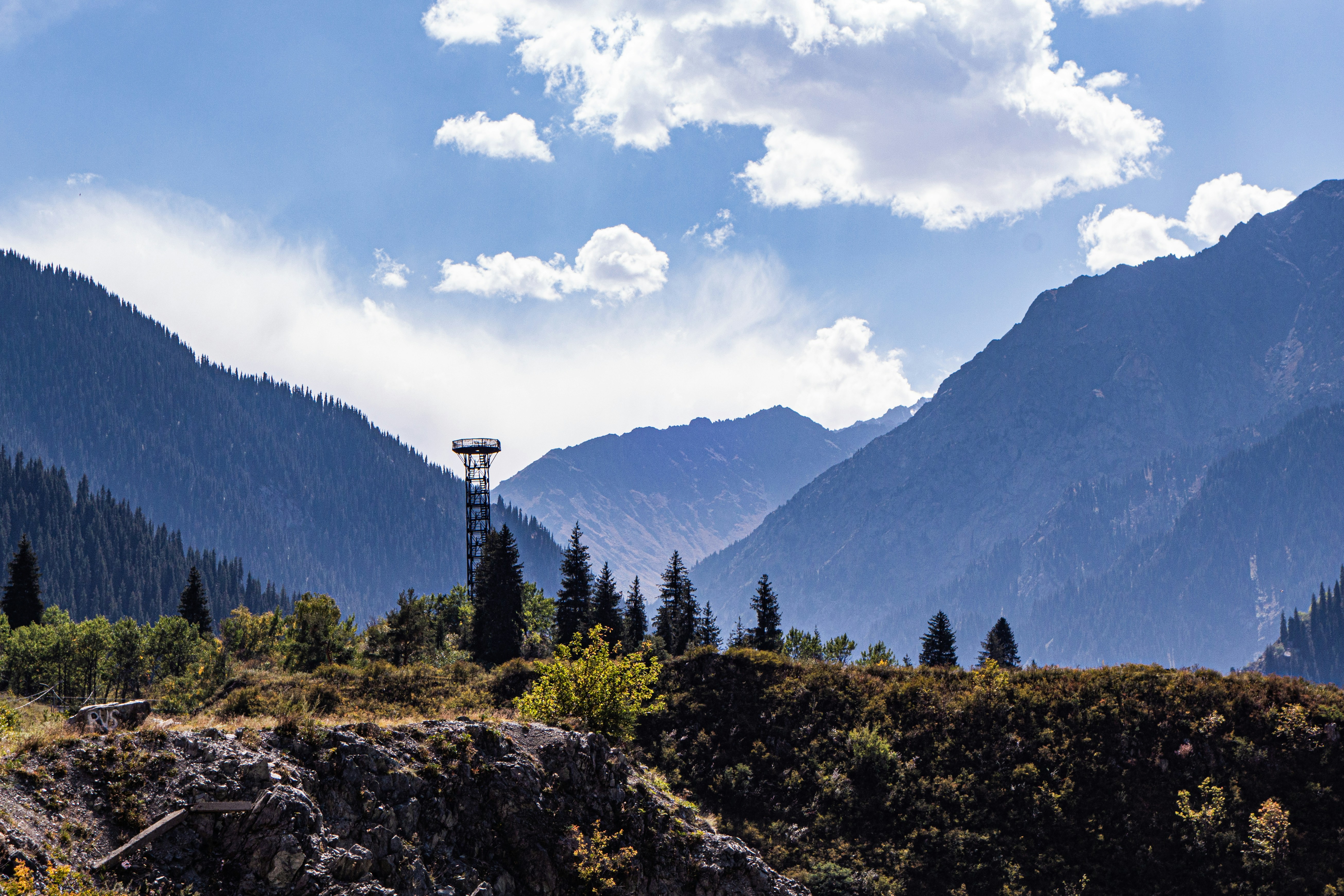 a view of a mountain range with a radio tower in the foreground