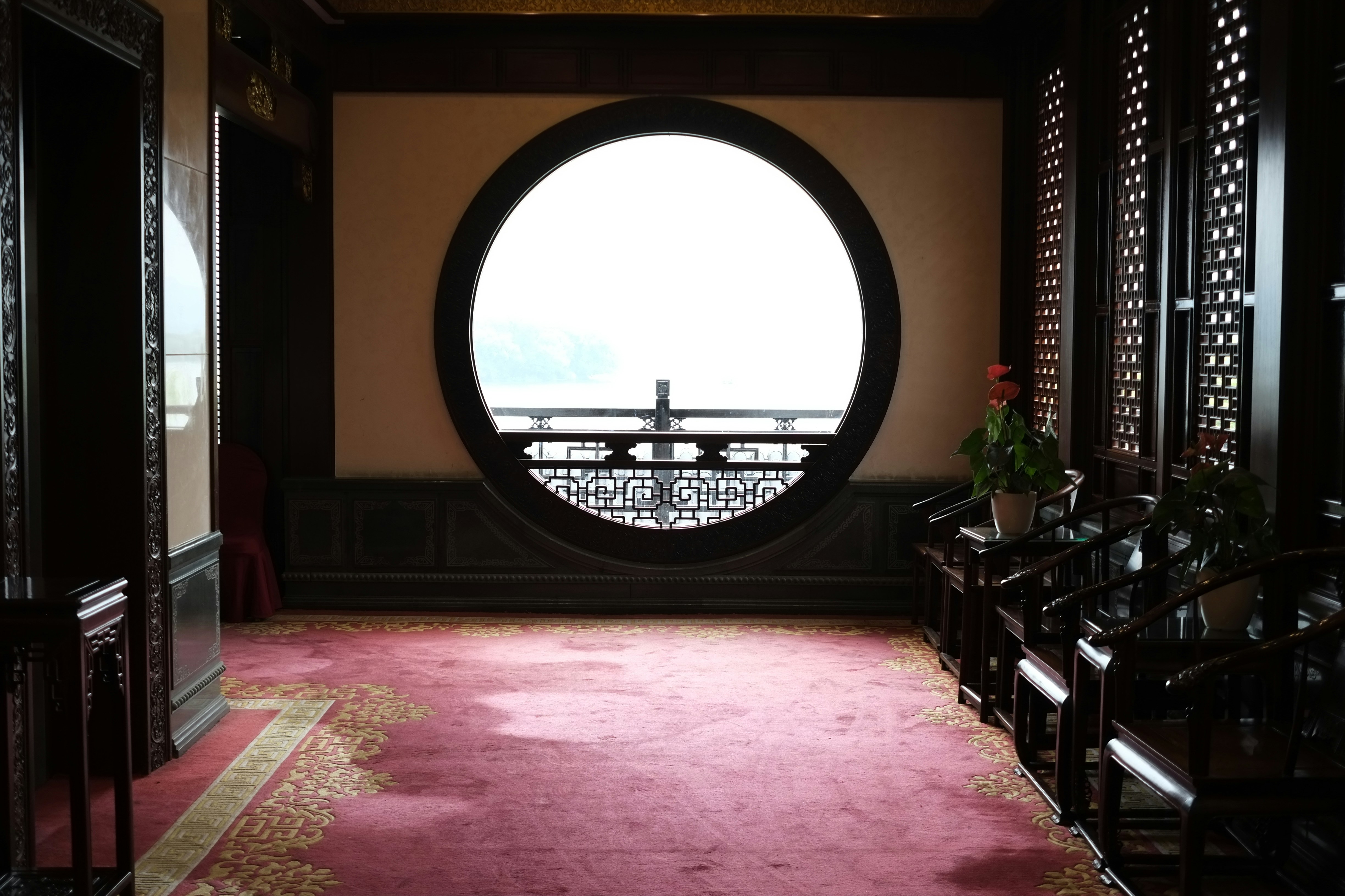 A large circular window in a room with a red carpet photo – Free Floor ...