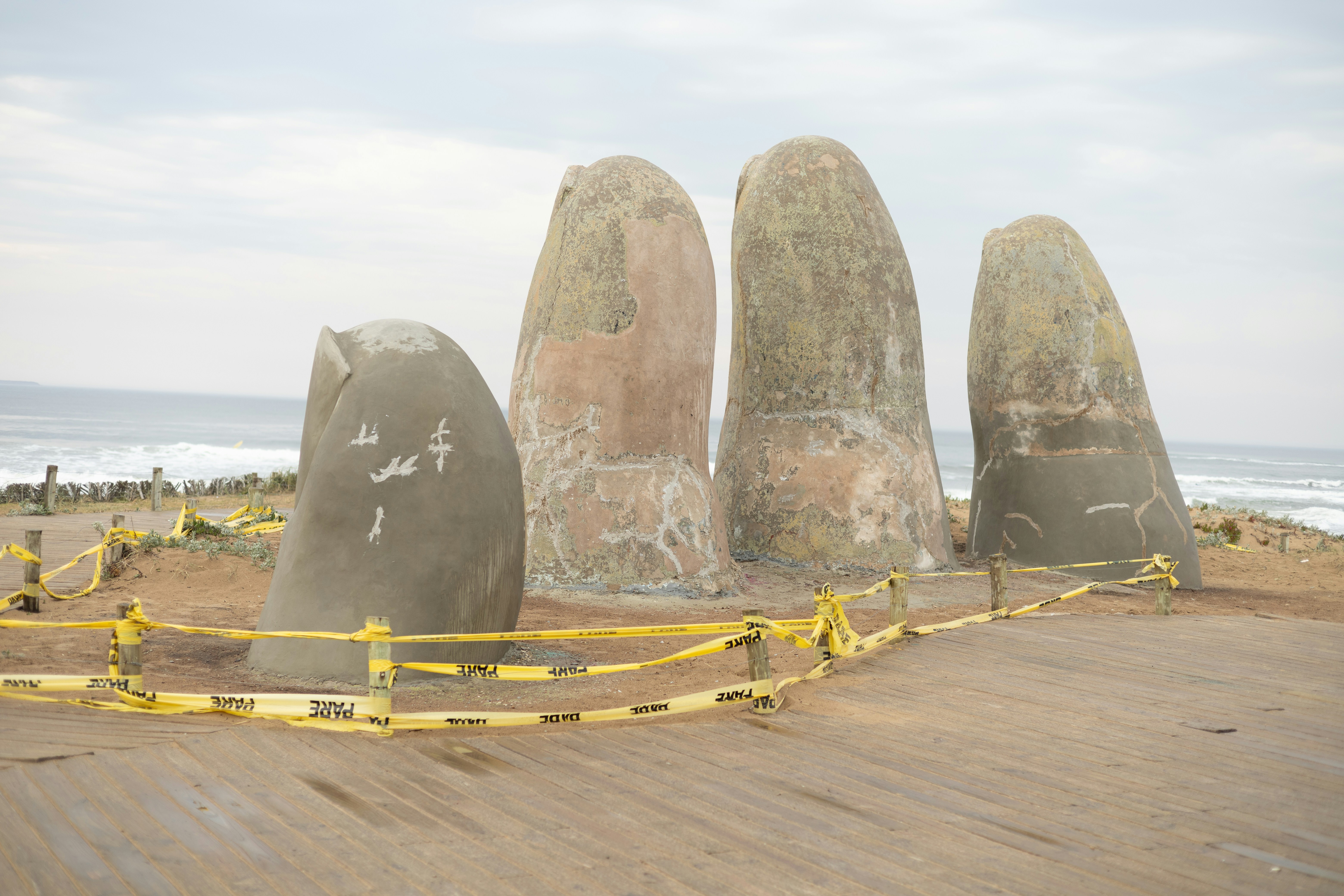 Wind-Whispered Monoliths Along a Caution-Taped Boardwalk