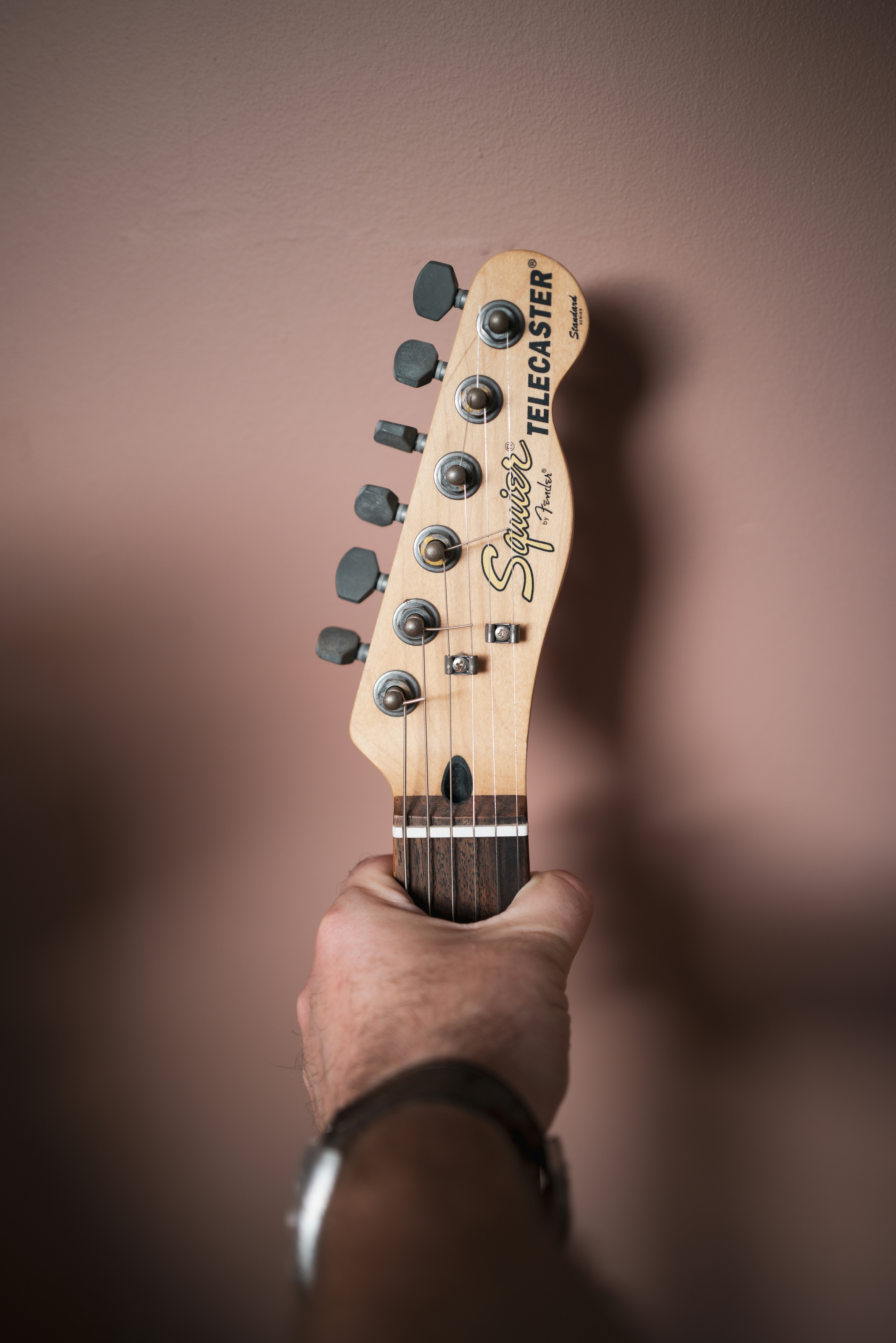 Grip and Glow: Portrait of a Telecaster Headstock in Hand