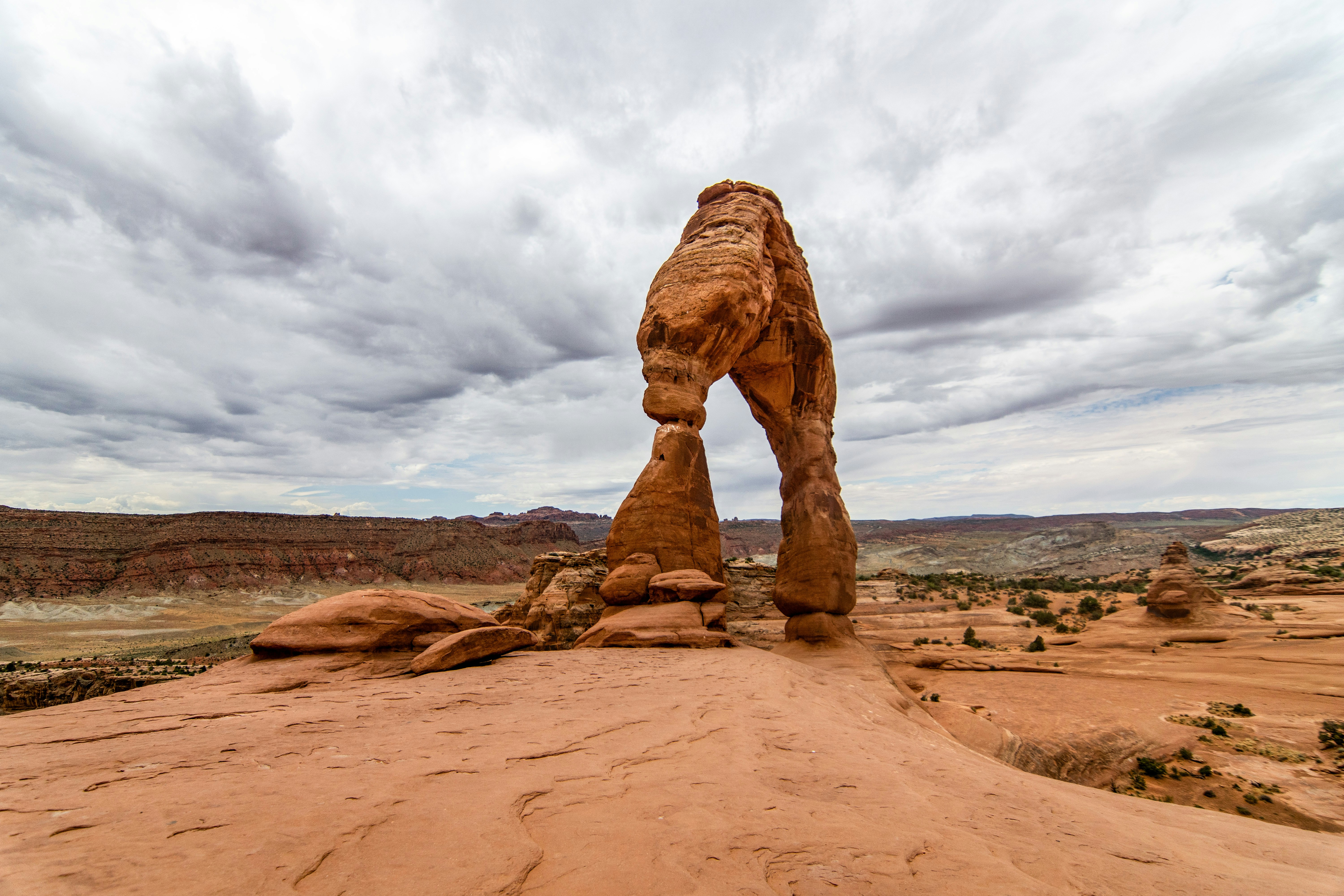 Red Rock Arch Framing a Desert Horizon Under Moody Skies