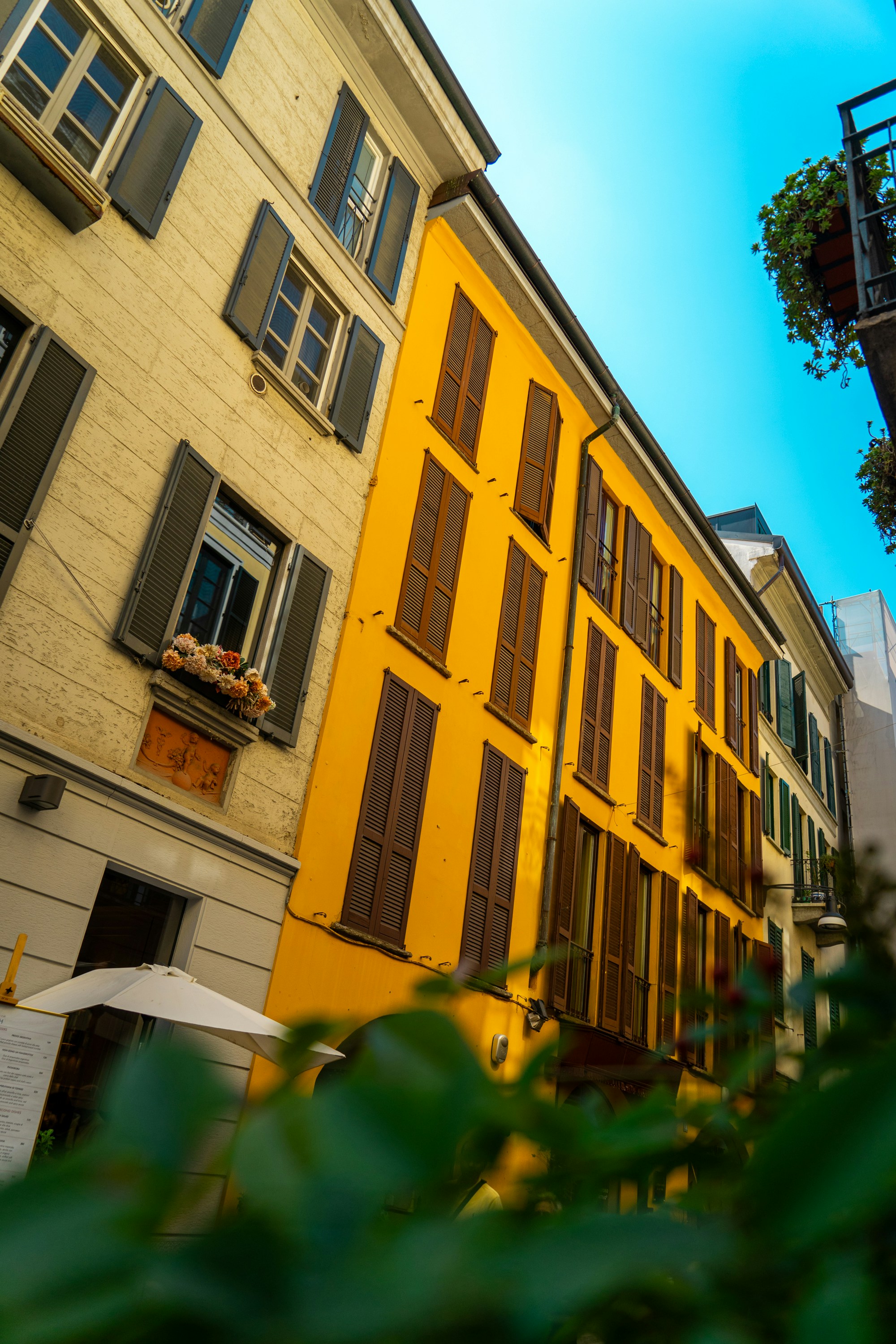 A tall yellow building sitting next to a tall building photo – Free ...