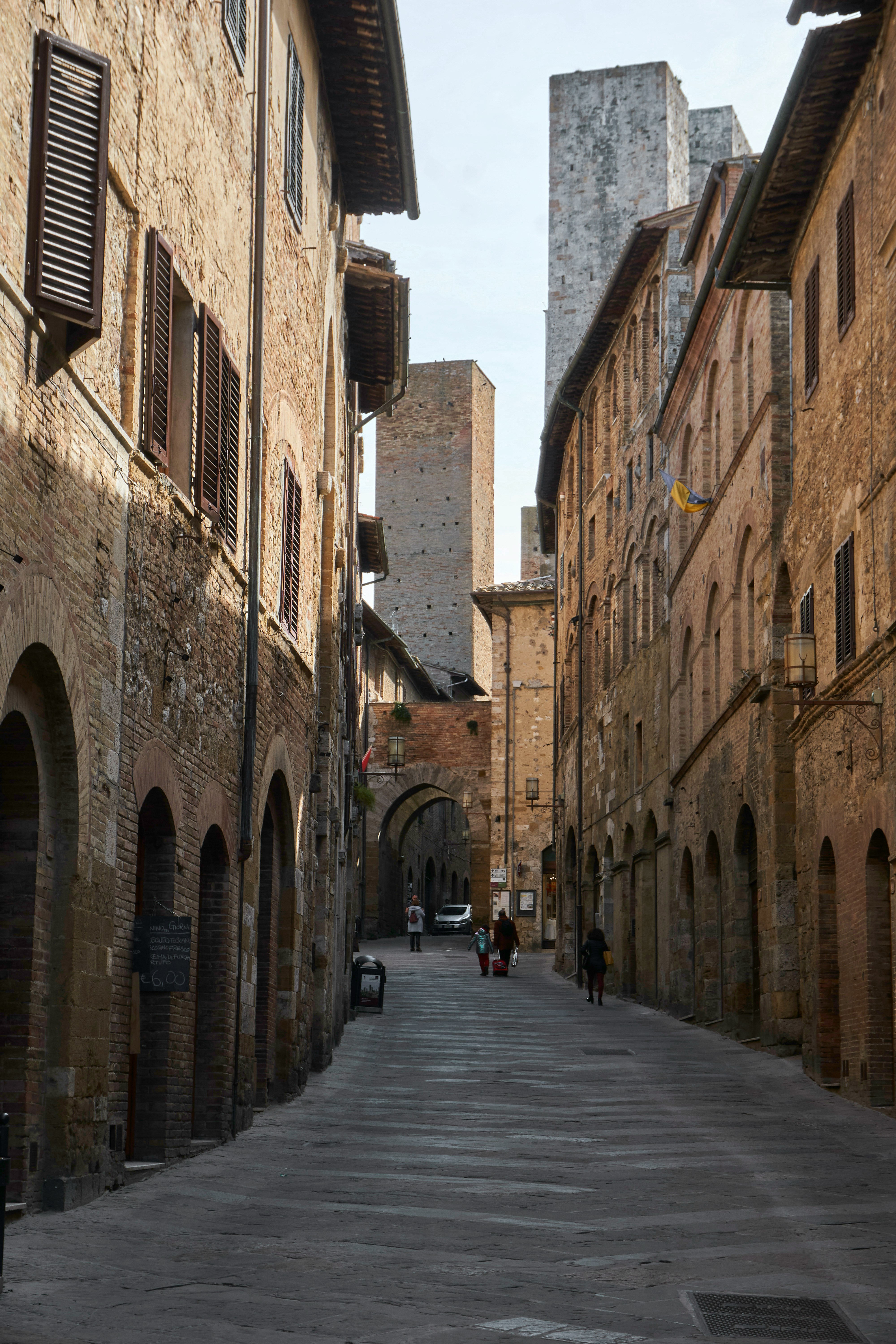 Una strada stretta con poche persone che camminano lungo di essa foto ...