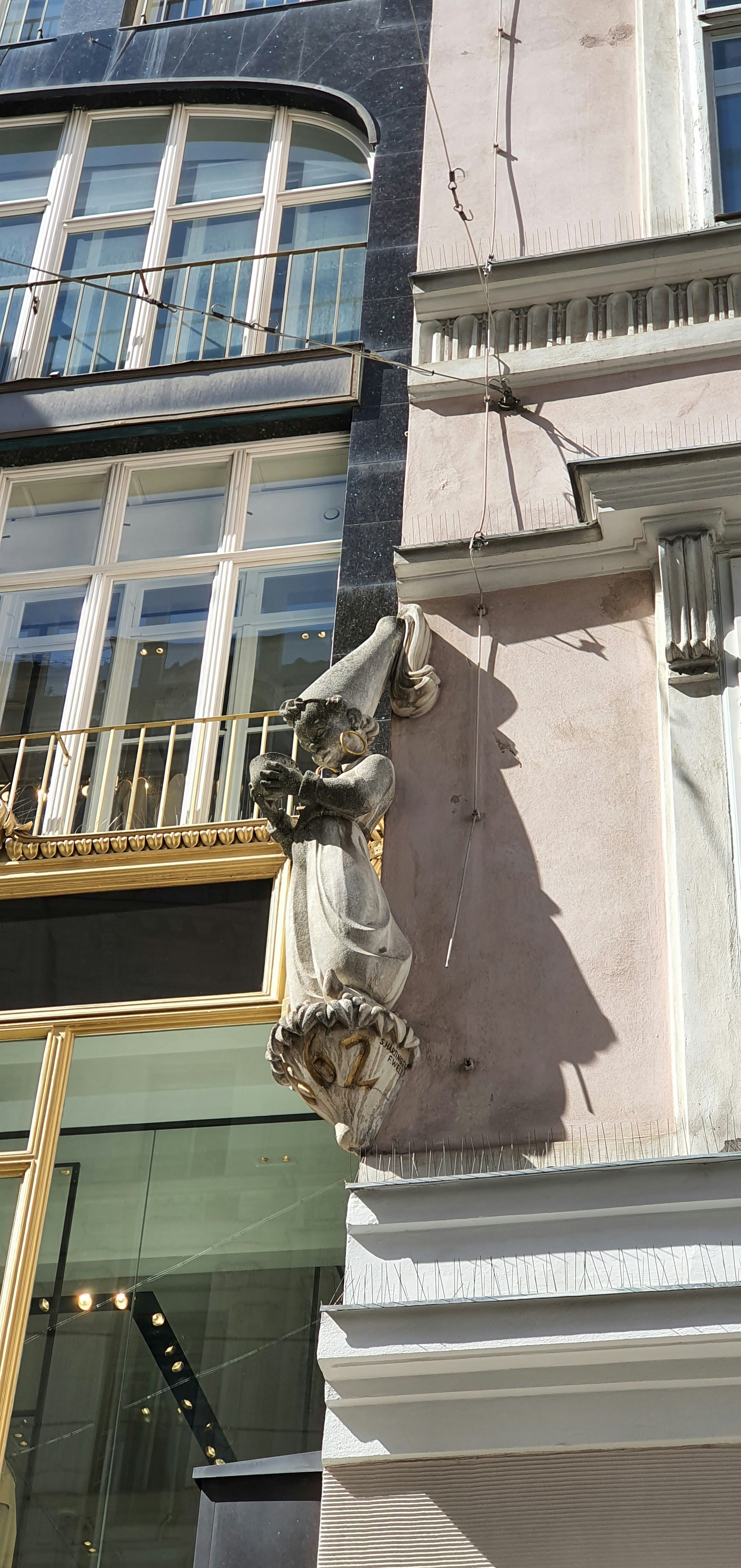 Stone Sentinel on a Glass-Fronted Facade