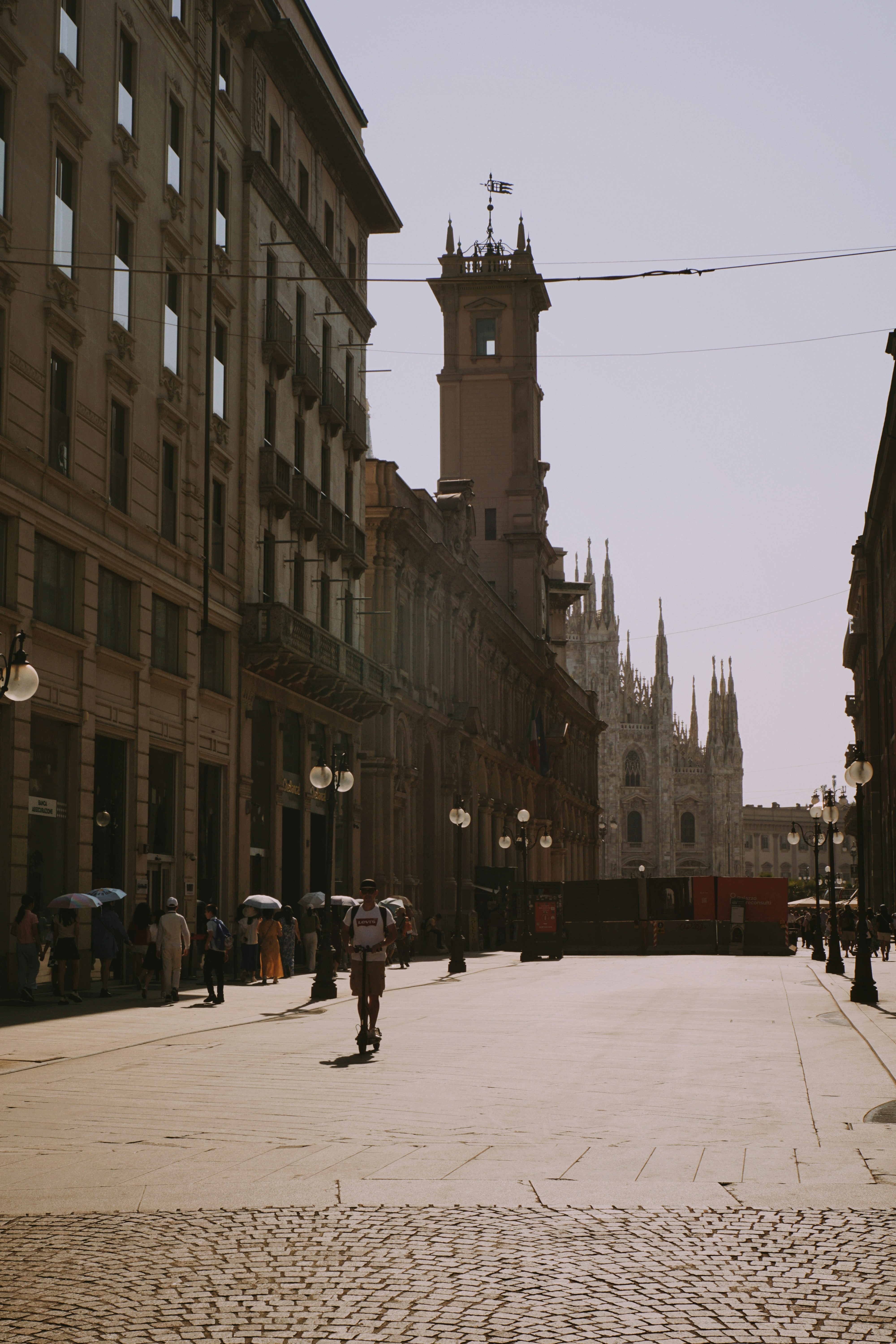 Lone Pedestrian Beneath a Sunlit Street Toward a Gothic Cathedral