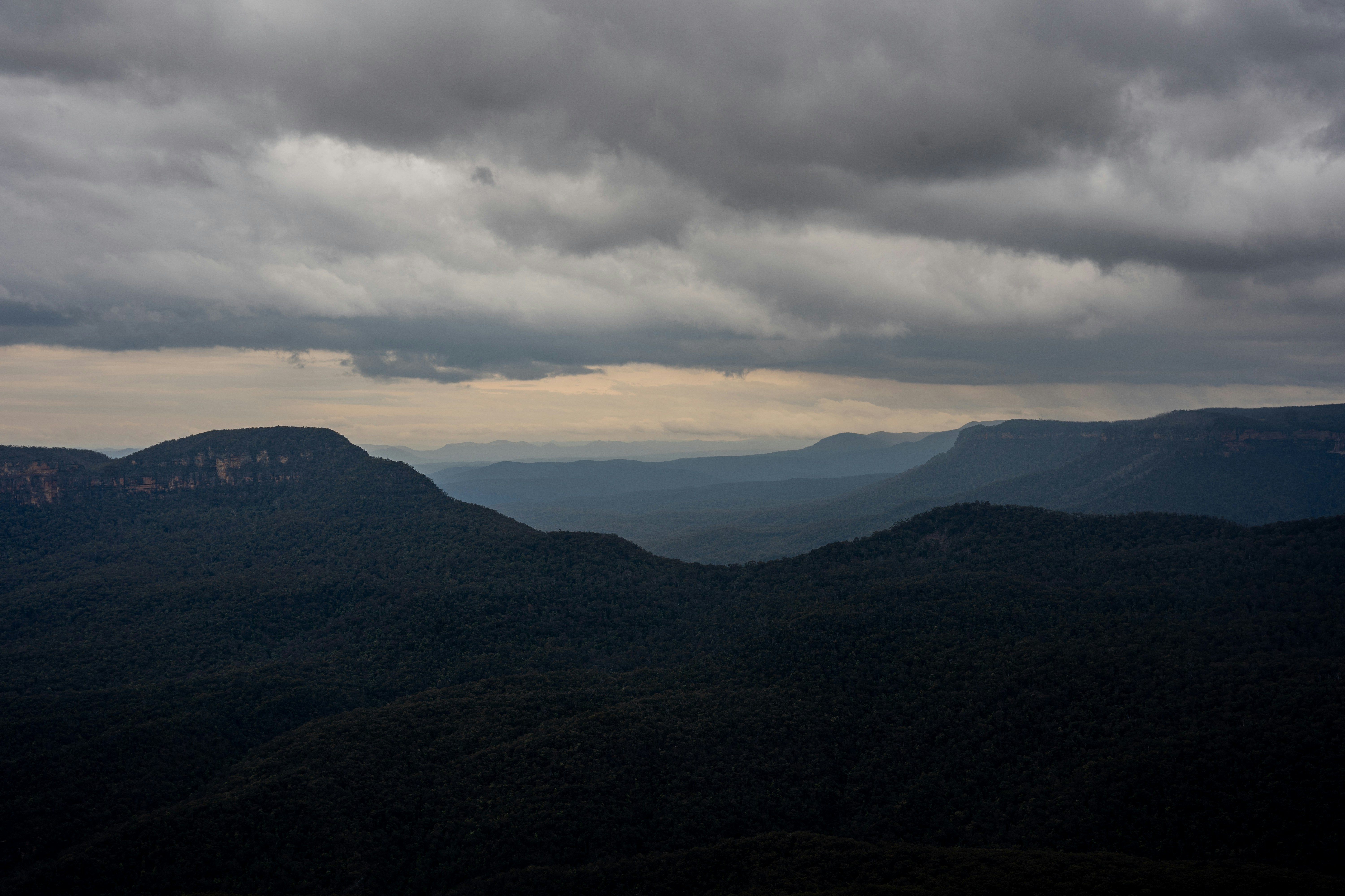 Horizon Whisper: Distant Ridges Beneath a Brooding Sky