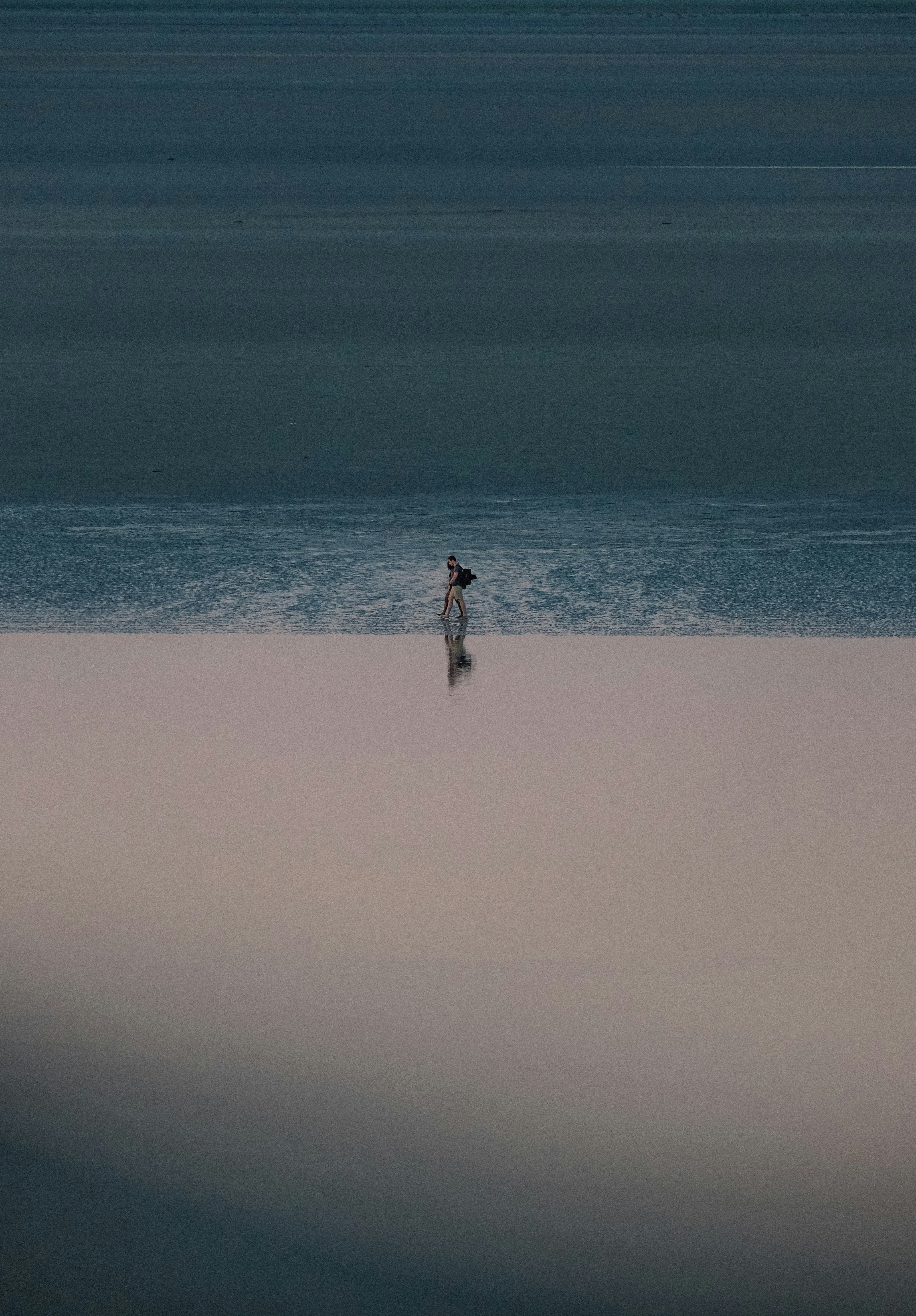 A person standing in the middle of a large body of water photo – Free ...