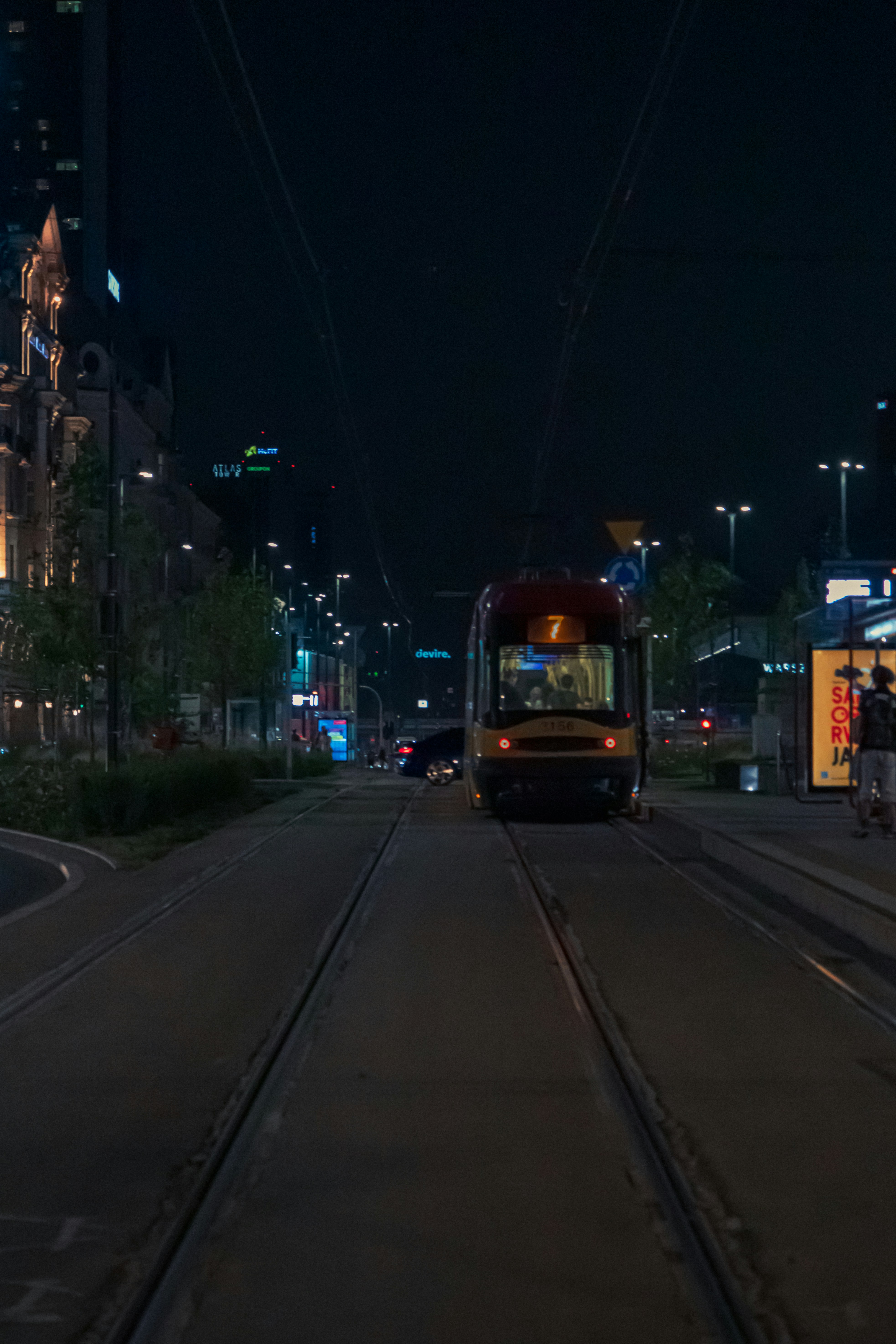Nocturne on Rails: a Red Streetcar Winds Through a Quiet City Night