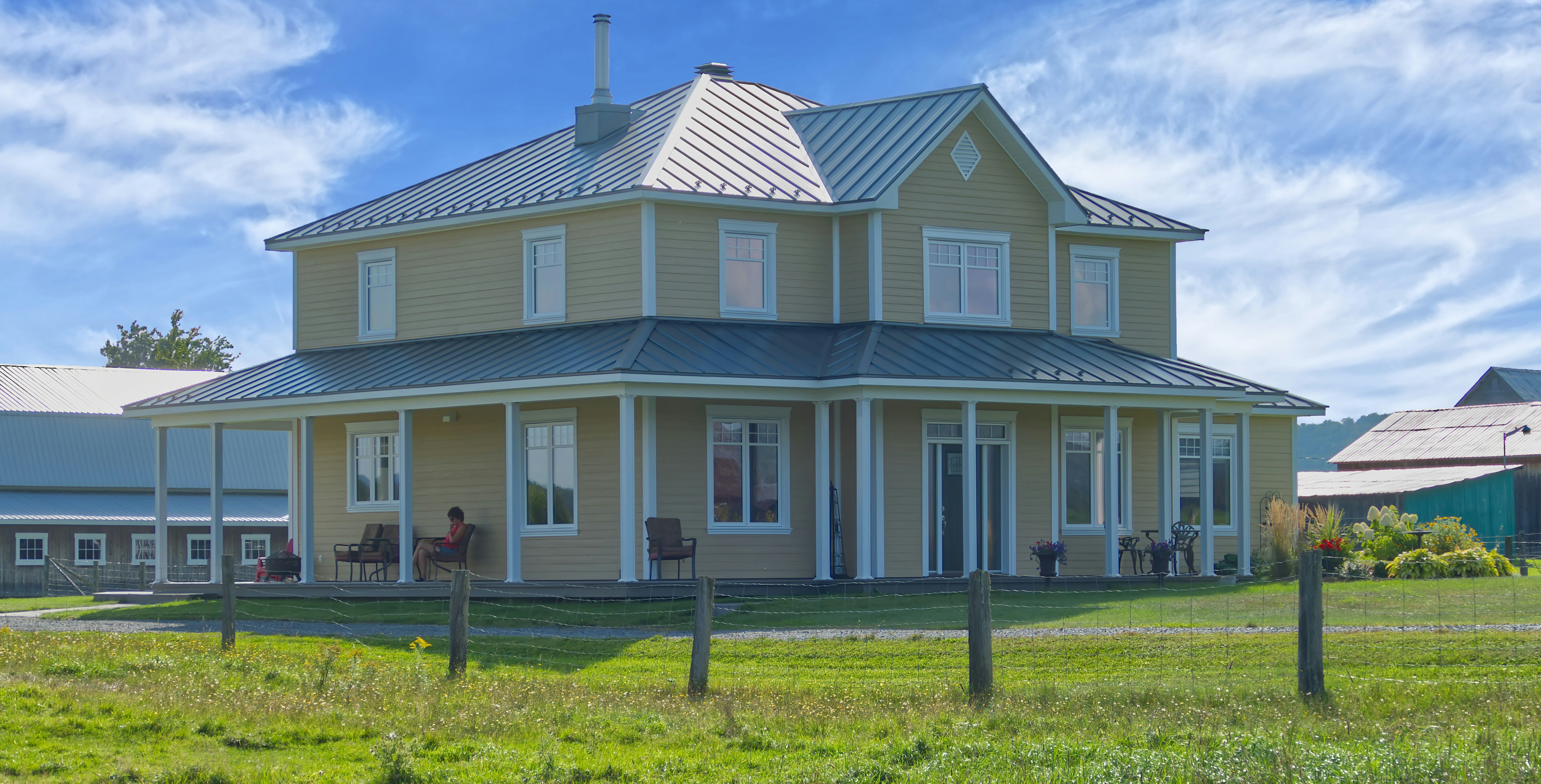 A large yellow house with a metal roof photo – Free House Image on Unsplash