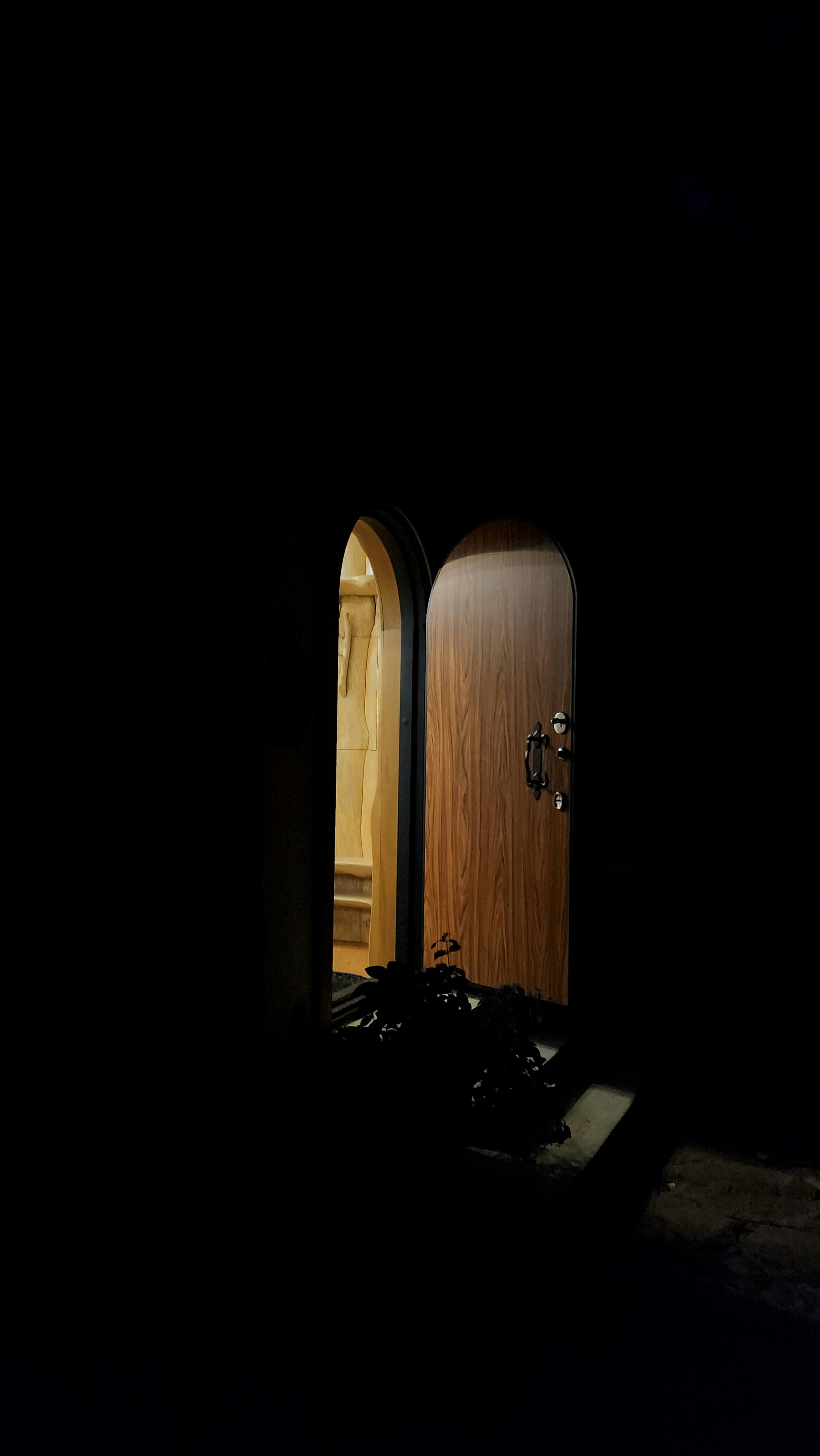 Illuminated doorway revealing warm interior against a dark backdrop, inviting curiosity and intrigue.