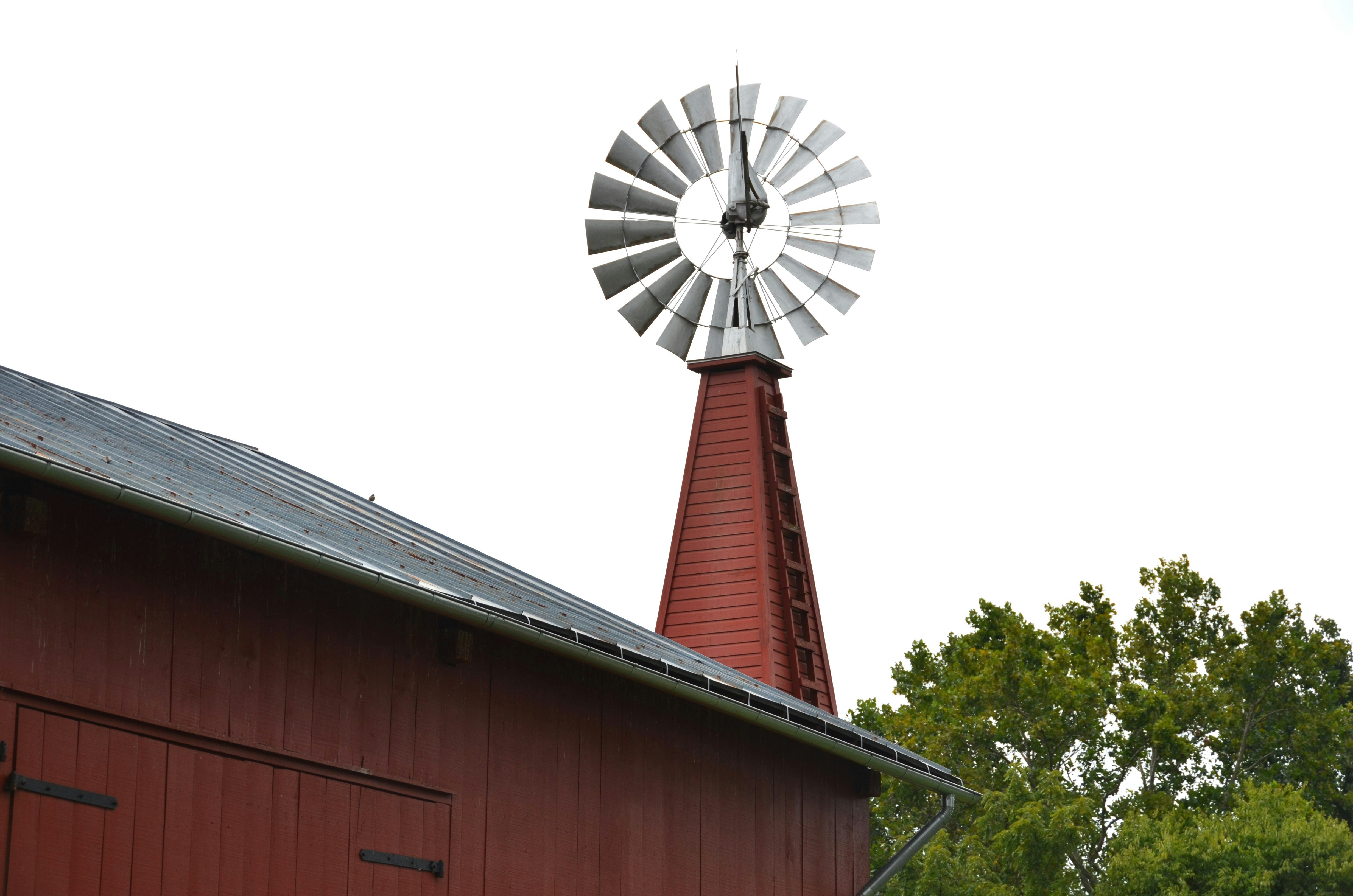 A red barn with a windmill on top of it photo – Free Machine Image on ...