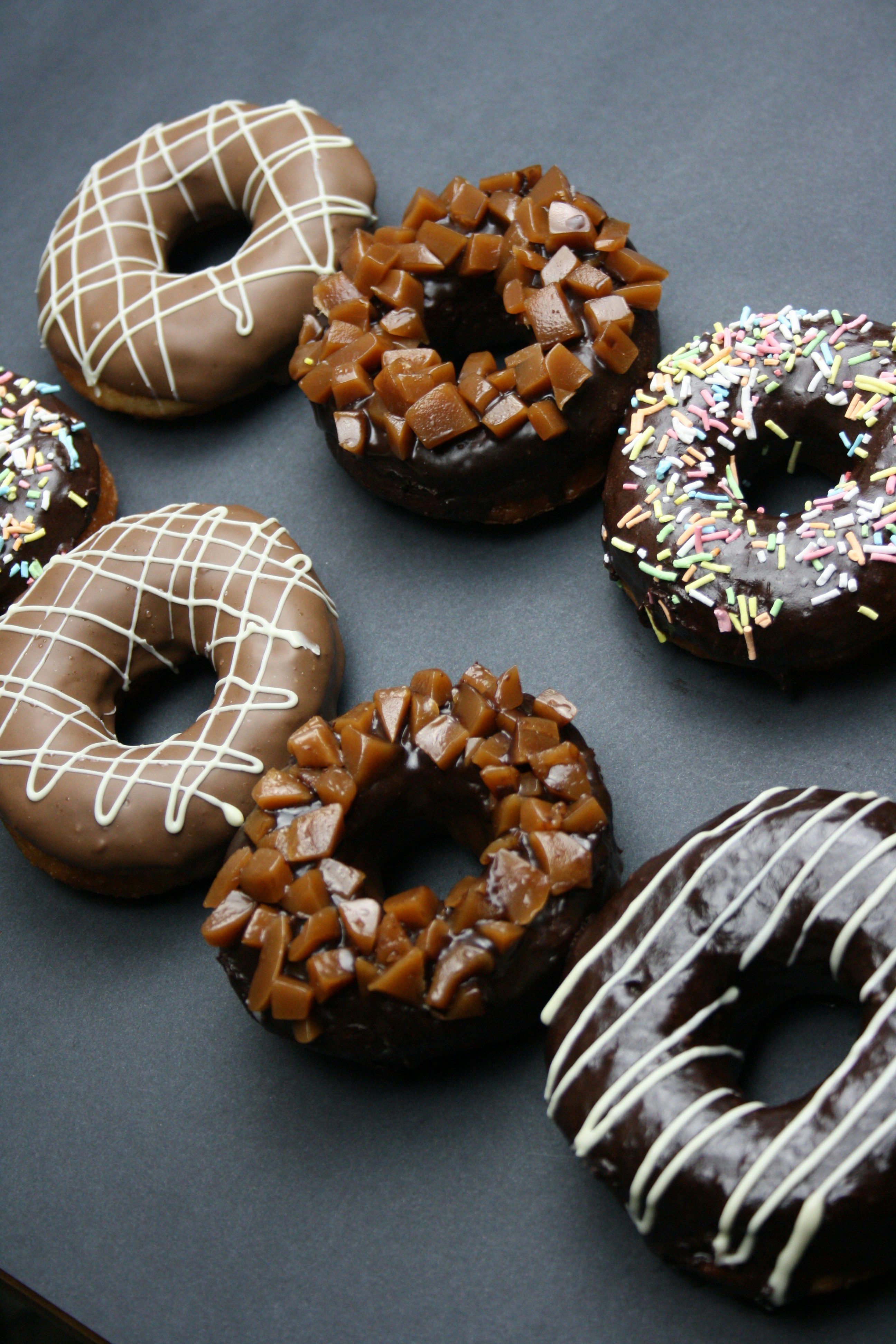 A bunch of doughnuts that are on a table photo – Free Donut Image on ...