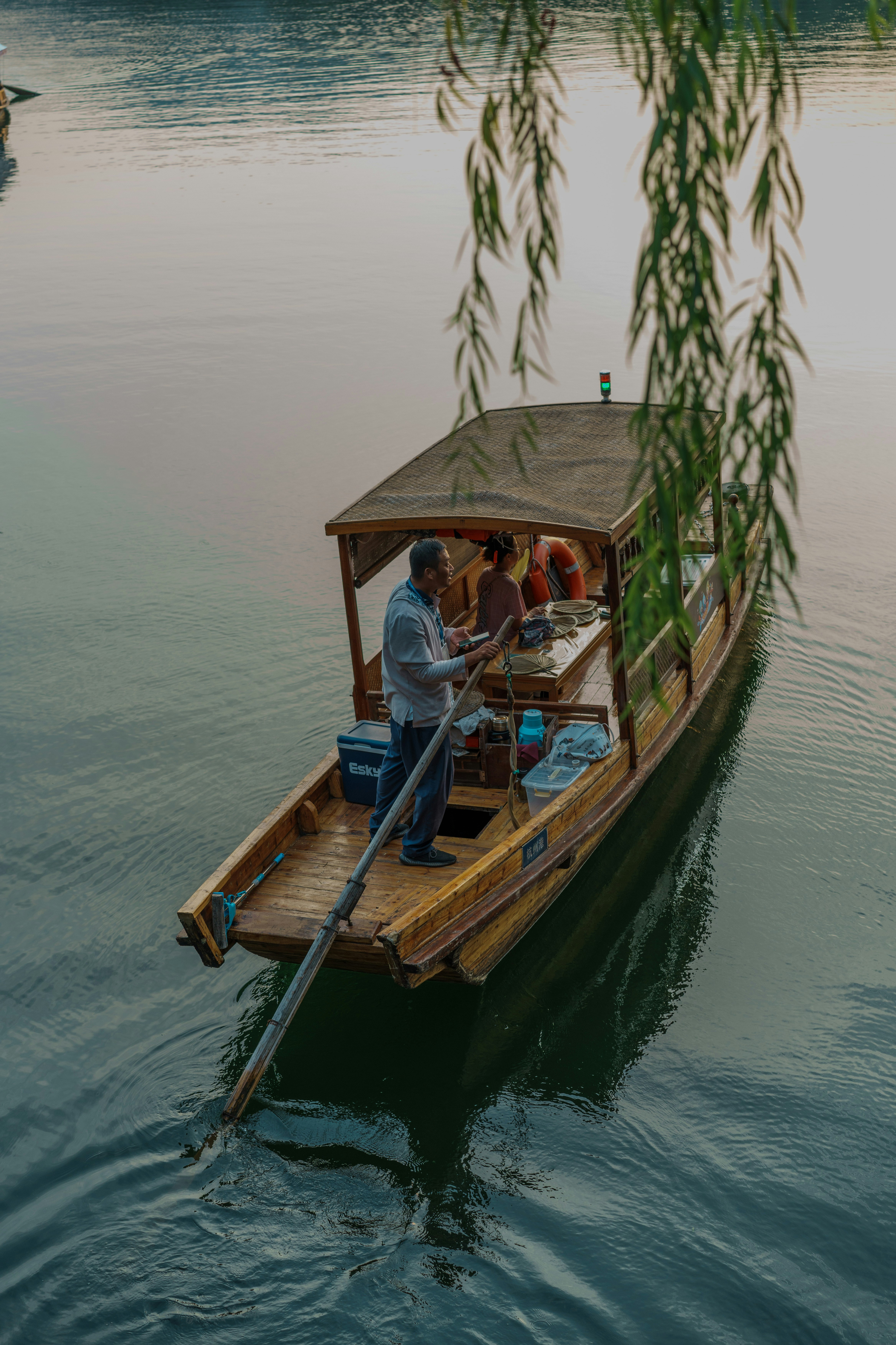 Riverfront Kitchen: A Wooden Boat Grill Gliding Across Quiet Waters