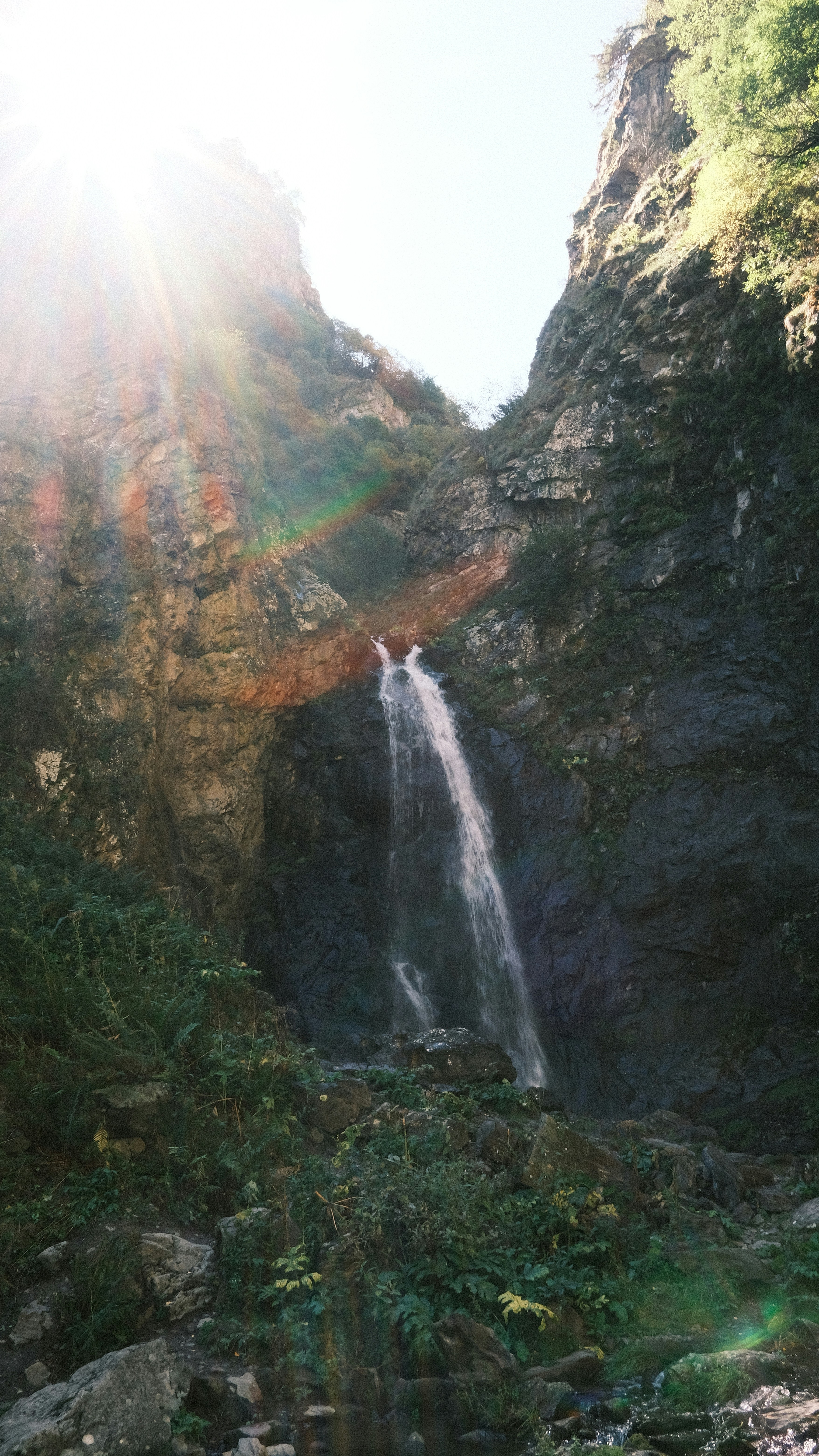 Sunlit Cascade Between Weathered Cliffs