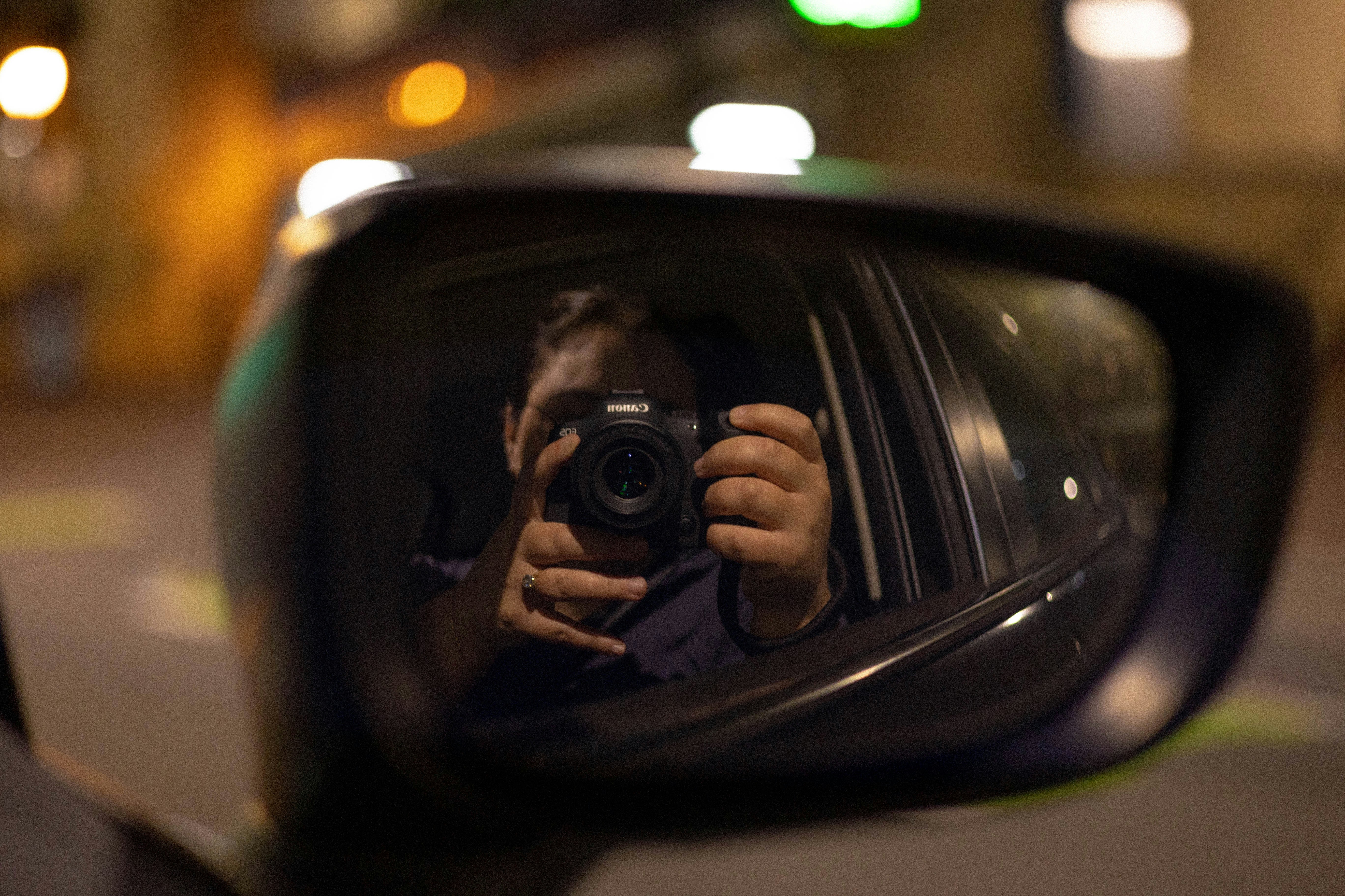 Rearview Reverie: Night Street Portrait Reflected in a Side Mirror