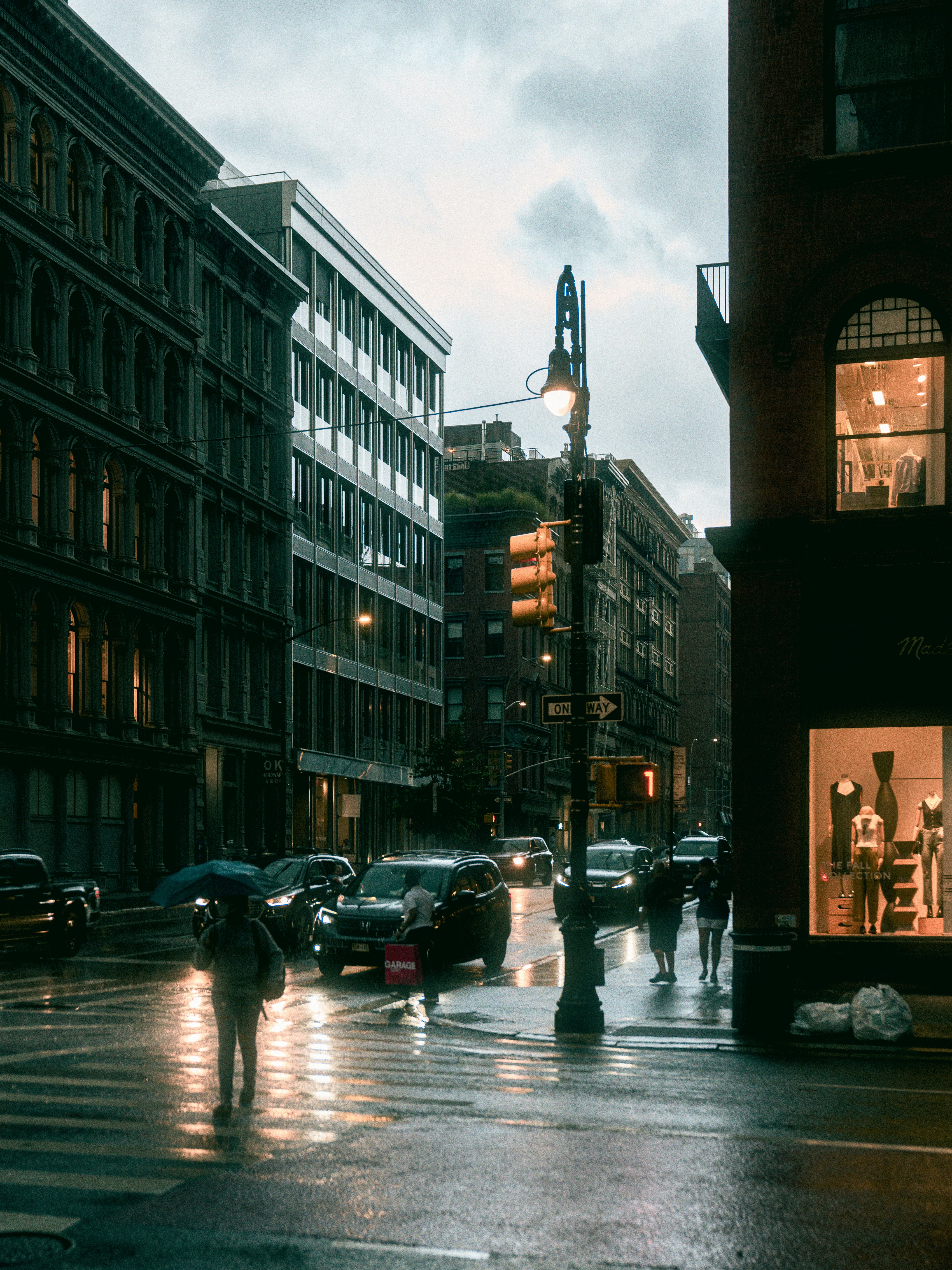 A group of people walking down a rain soaked street photo – Free Street ...
