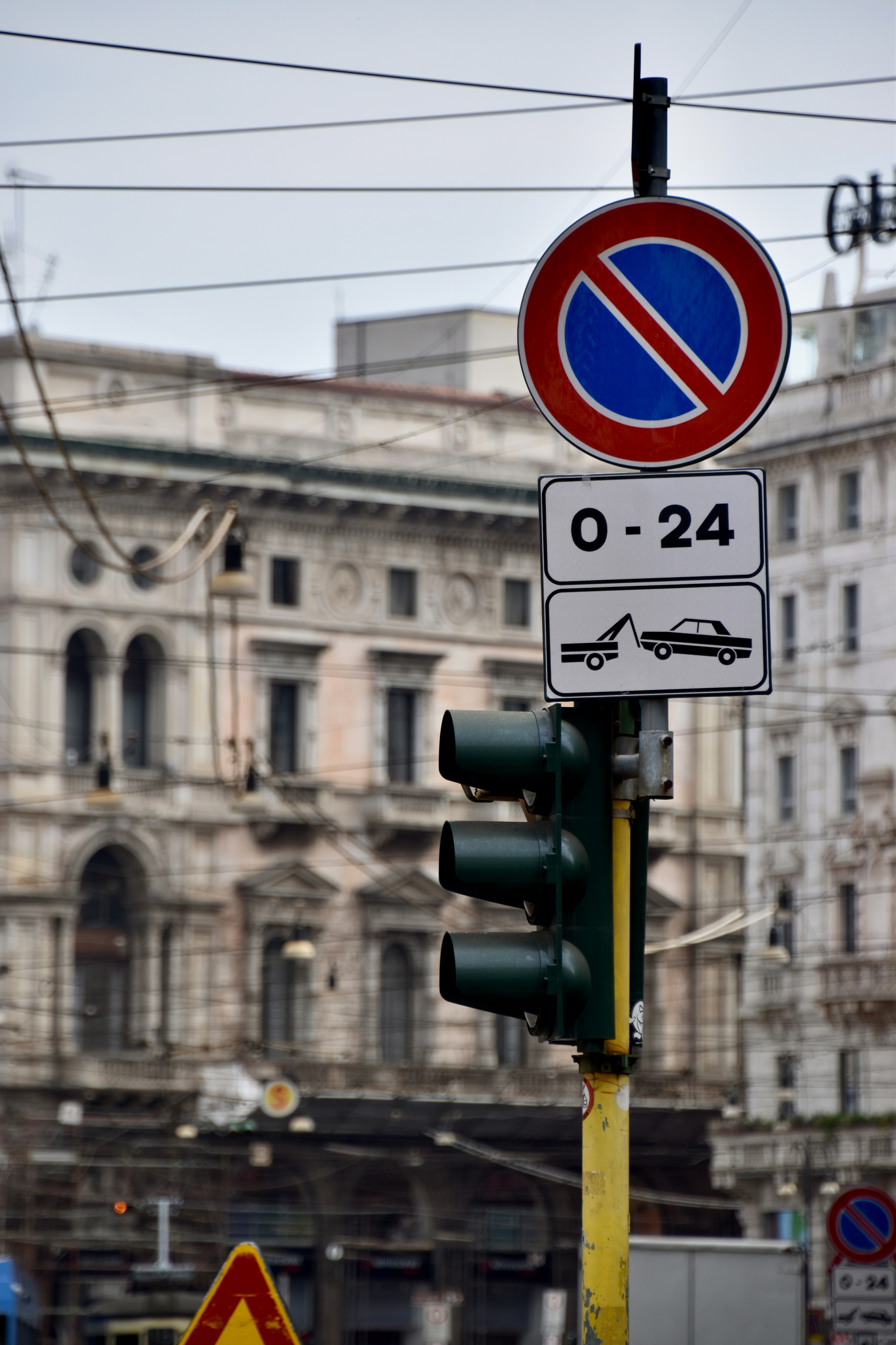 Urban Signpost: A No-Parking Moment Beneath Neon Wires