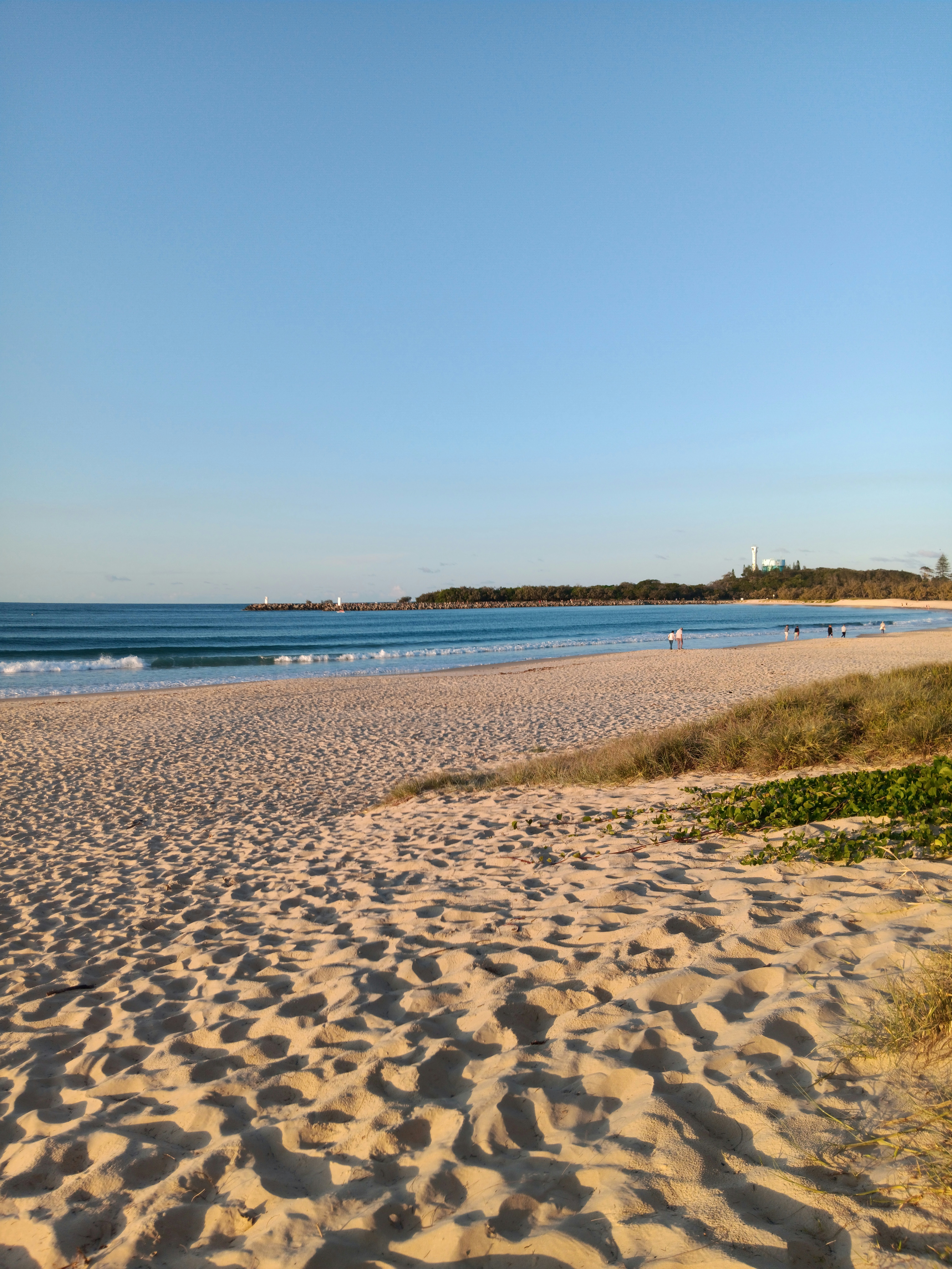 A sandy beach with waves coming in from the ocean photo – Free ...