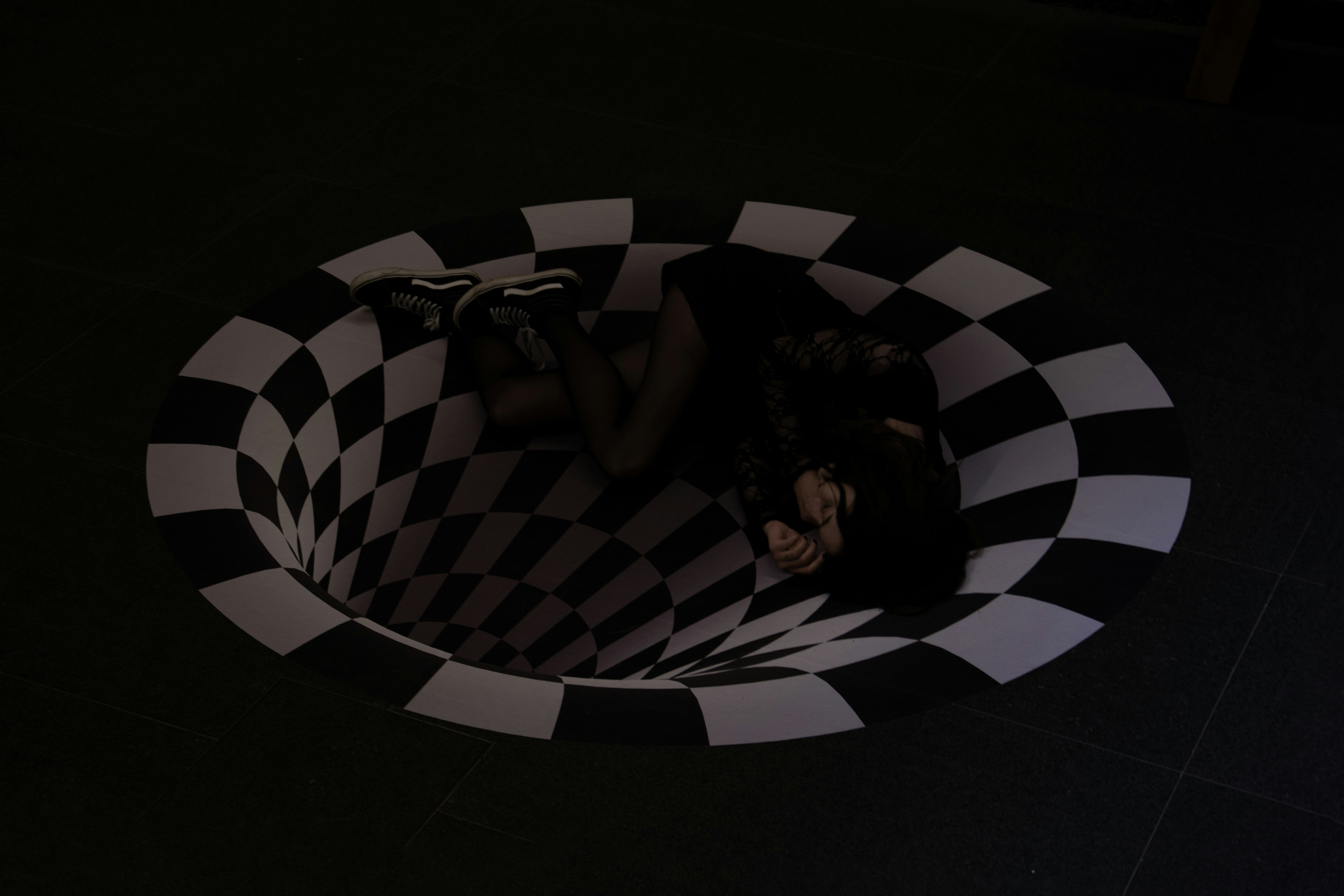 Checkerboard Abyss: A Quiet Figure at the Rim of a Circular Floor Portal
