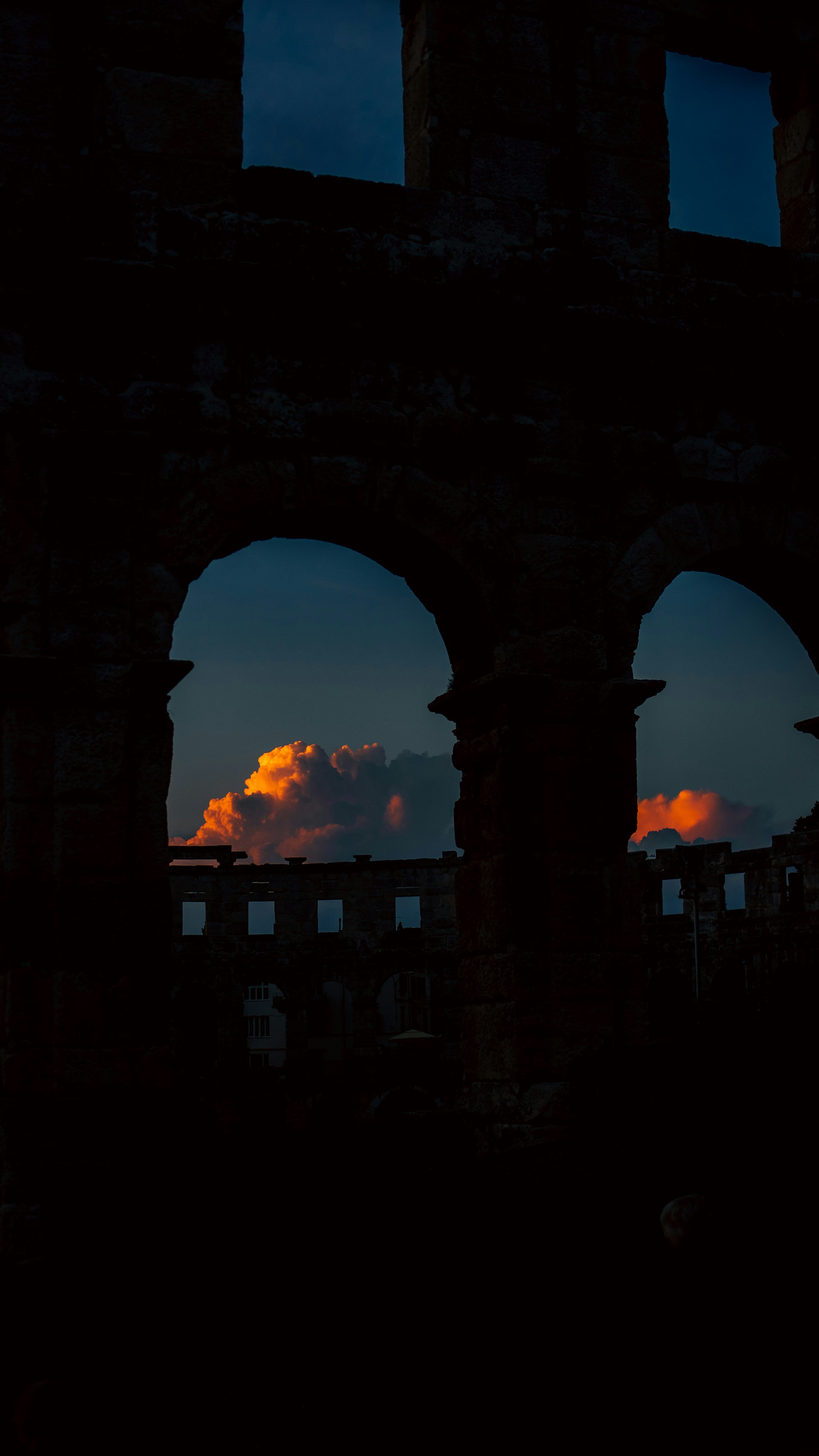 A view of a sunset through an arch in a building photo – Free Pula ...