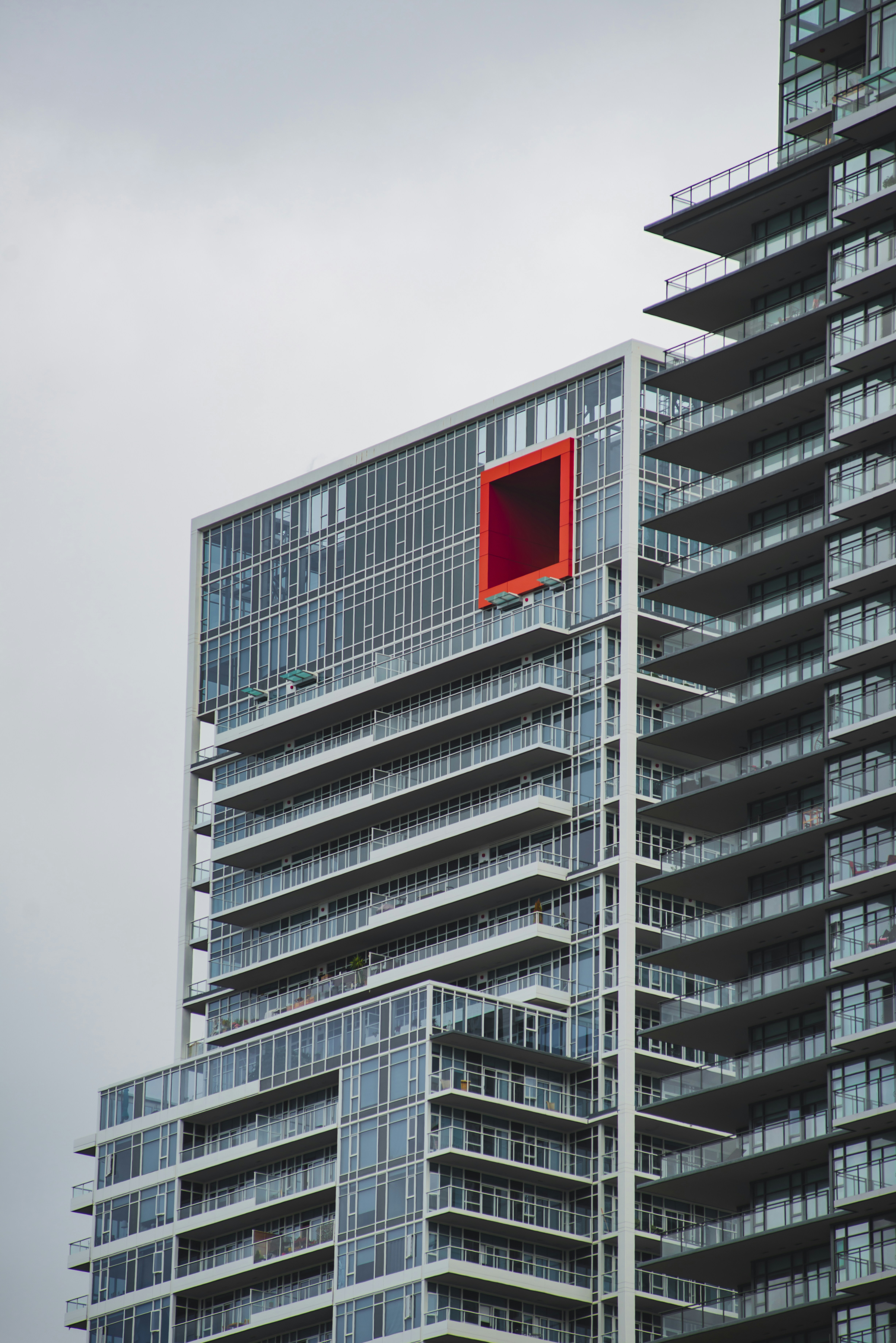 A tall building with a red square in the middle of it photo – Free ...