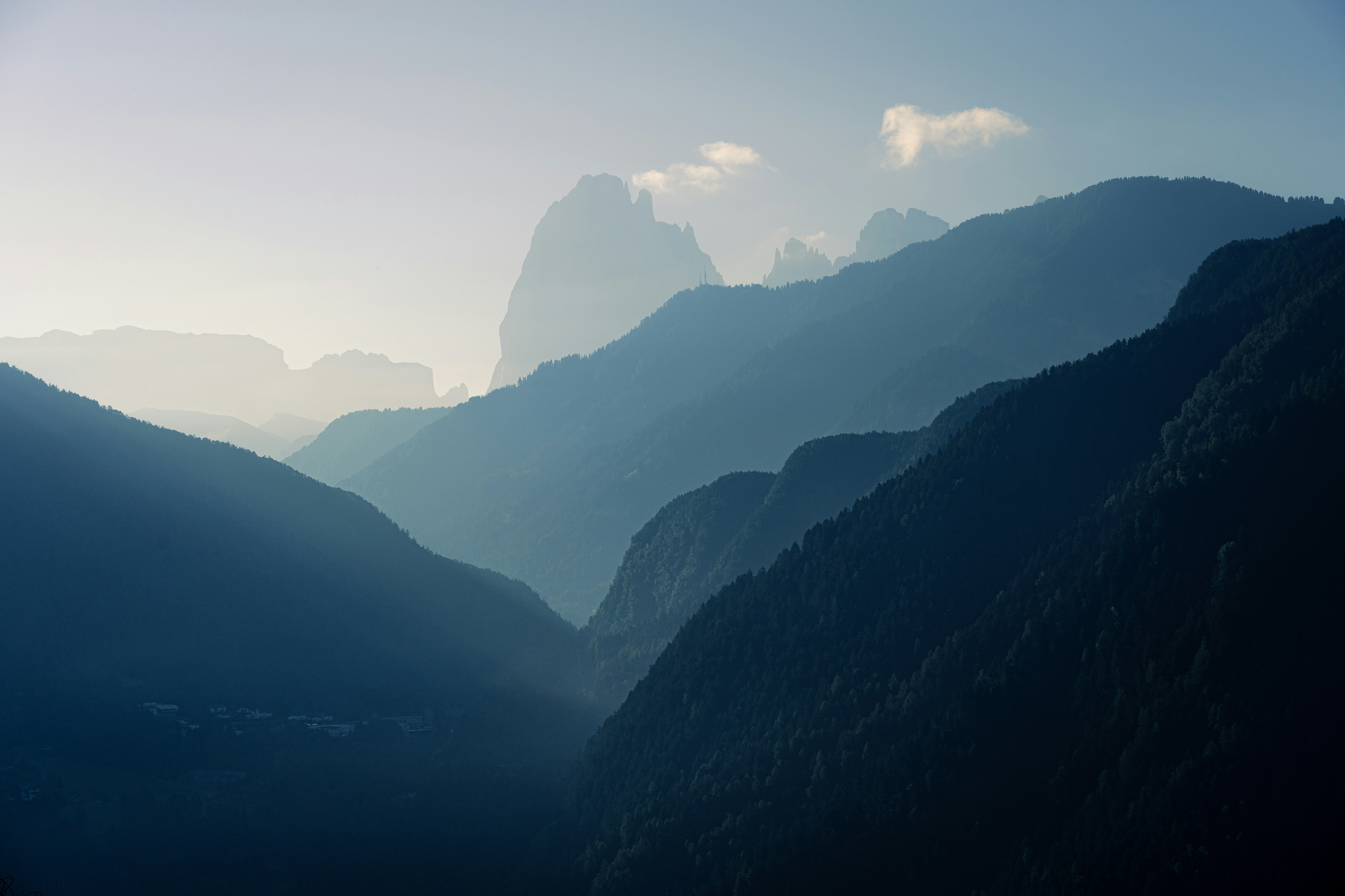Layered mountain ranges shrouded in mist, creating a serene atmosphere during twilight hours.